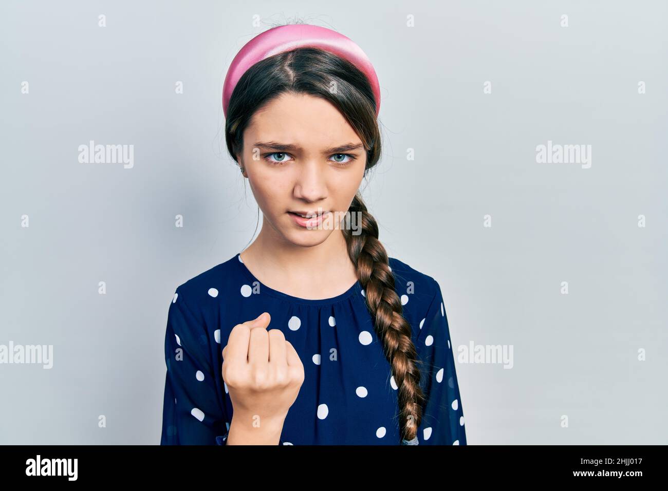 Young brunette girl wearing elegant look angry and mad raising fist ...