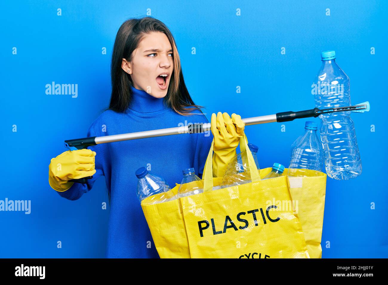 Young brunette girl holding recycling bag with plastic bottles and ...