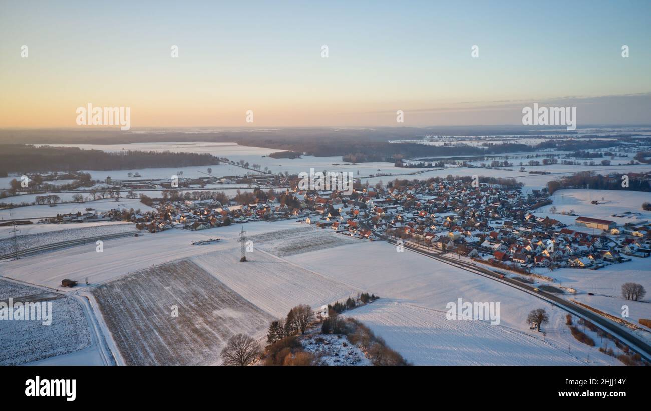 Chilling view of a snow-covered field in the countryside under a sunset ...