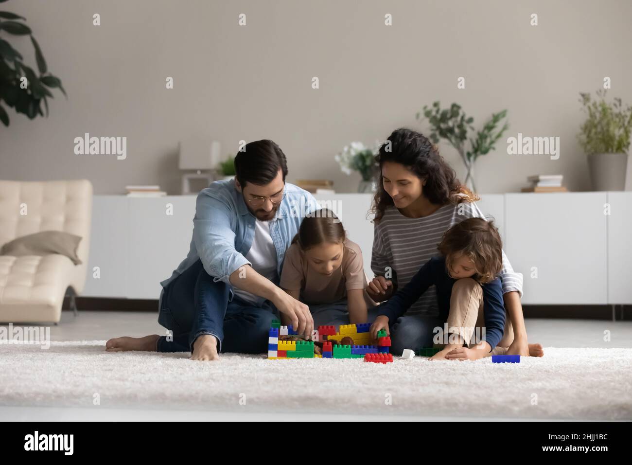 Couple with kids play cubes toys at home Stock Photo - Alamy