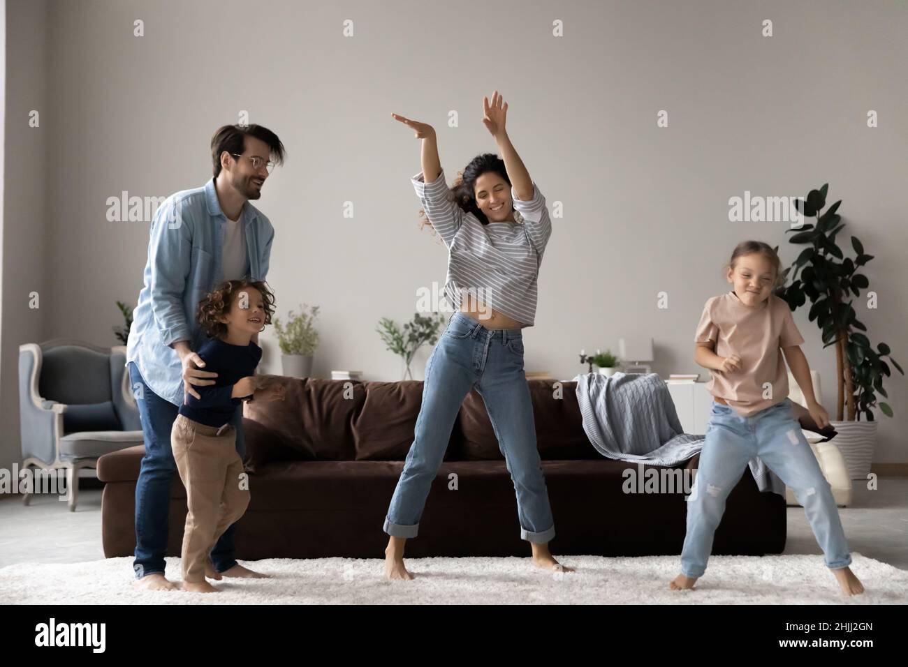 Untroubled family with children dancing together in living room Stock ...