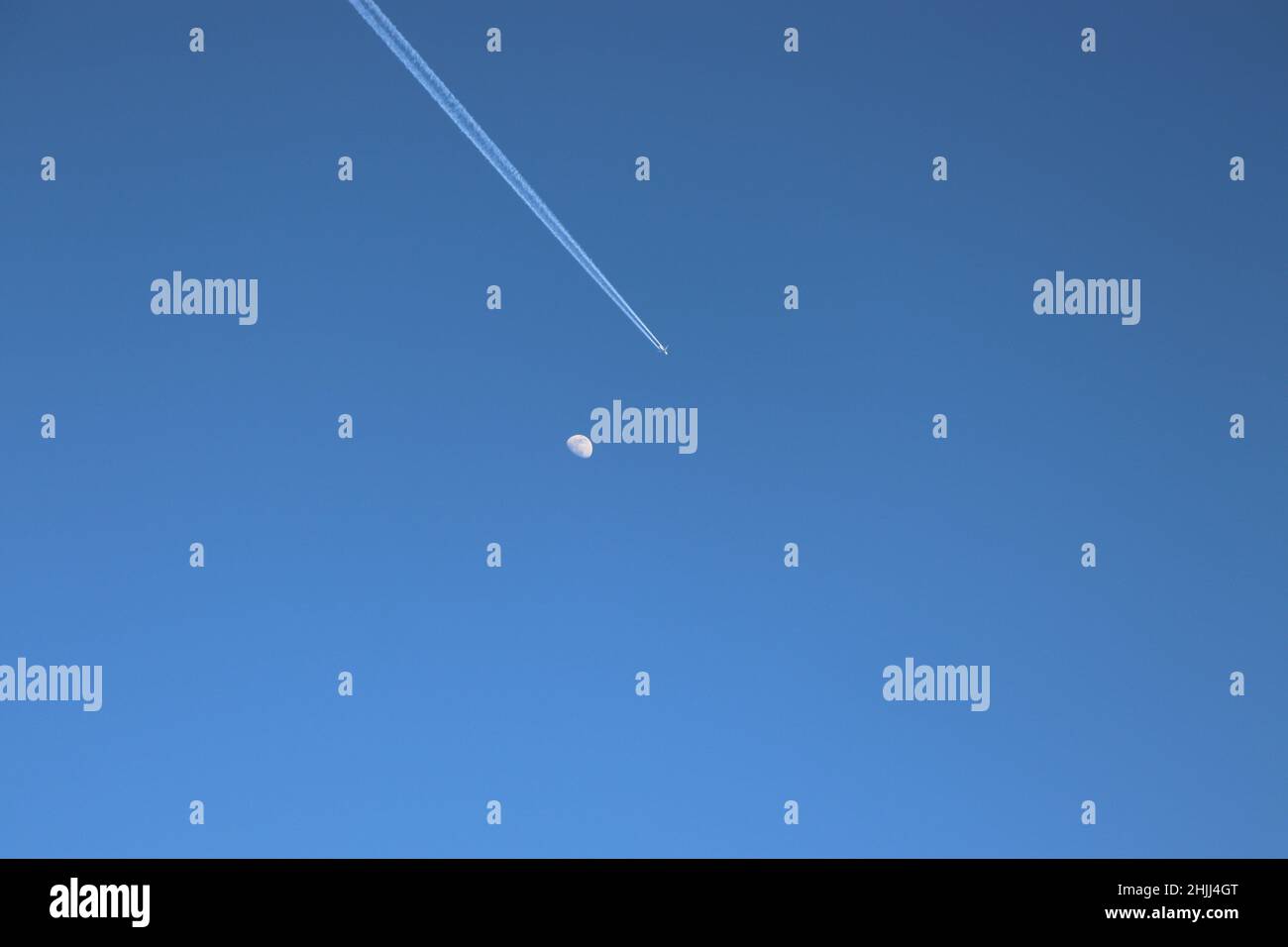 Scenic view of an airplane trace and the Moon in the blue sky Stock ...