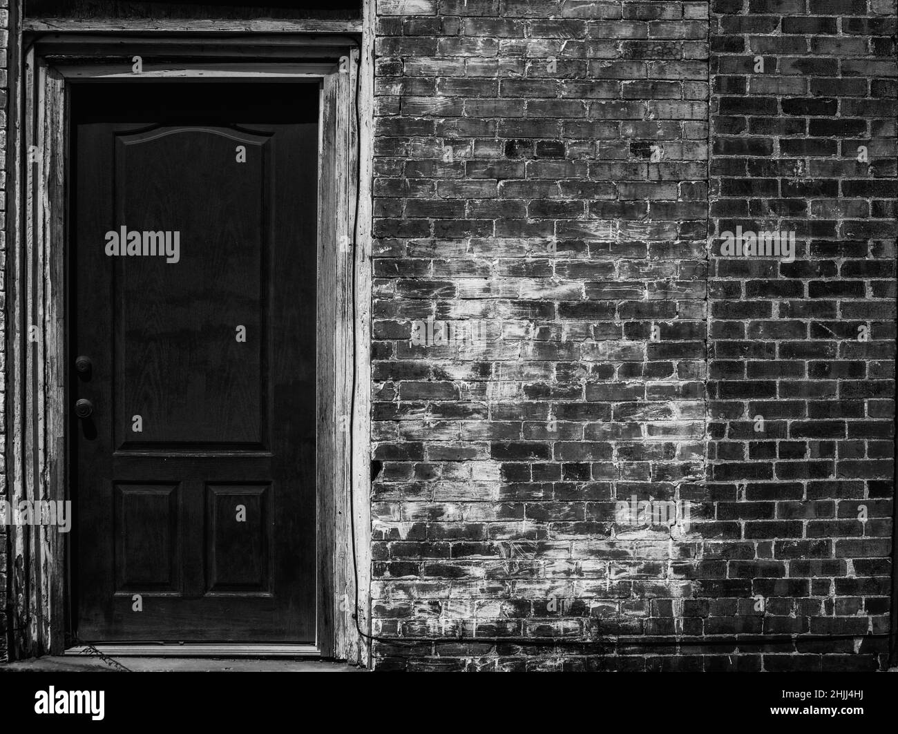 Grayscale shot of the door of an old brick building Stock Photo - Alamy
