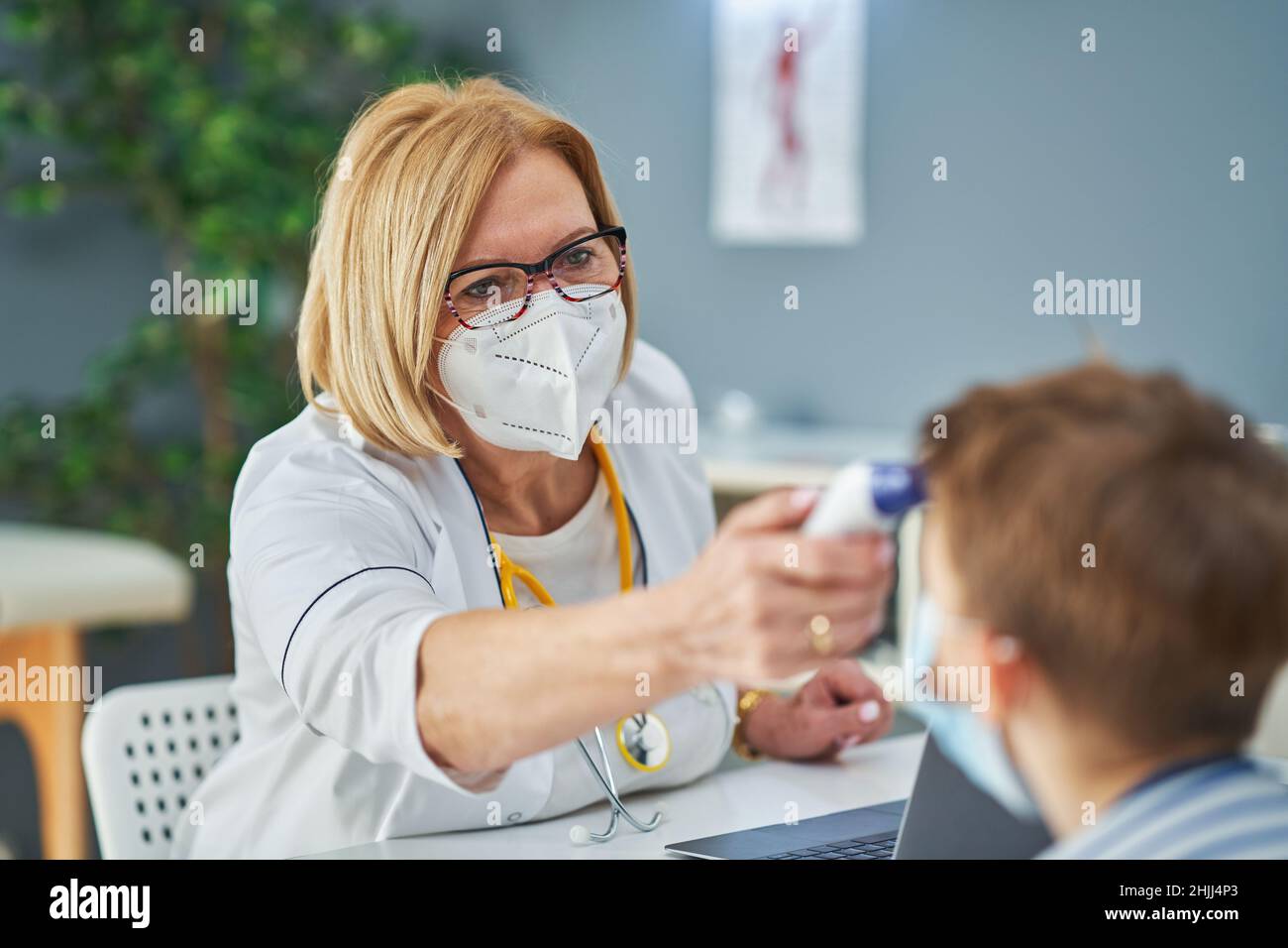 Pediatrician doctor examining little kids in clinic temperature check ...