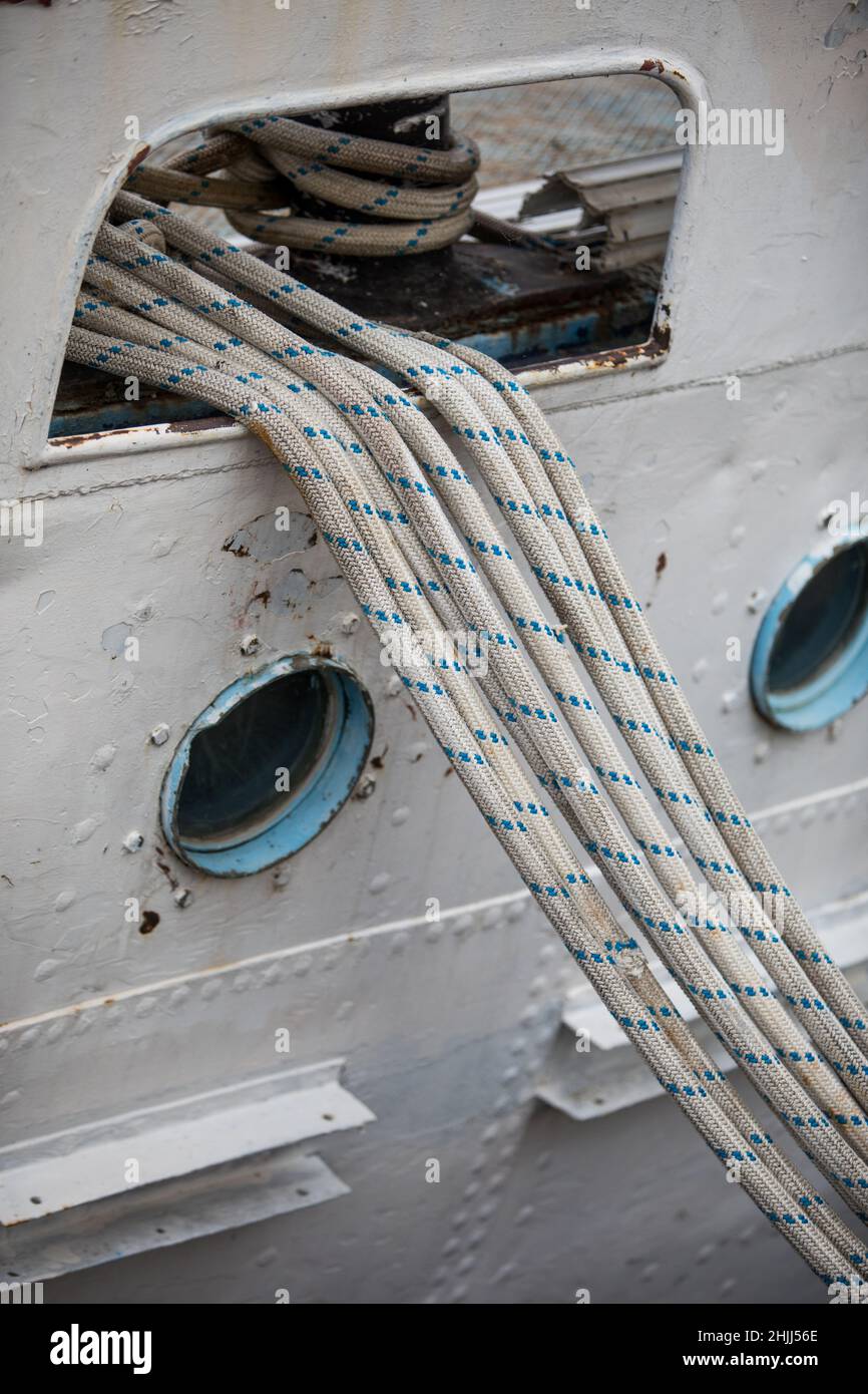 Old rusty ship with ropes tied to mooring wall Stock Photo - Alamy