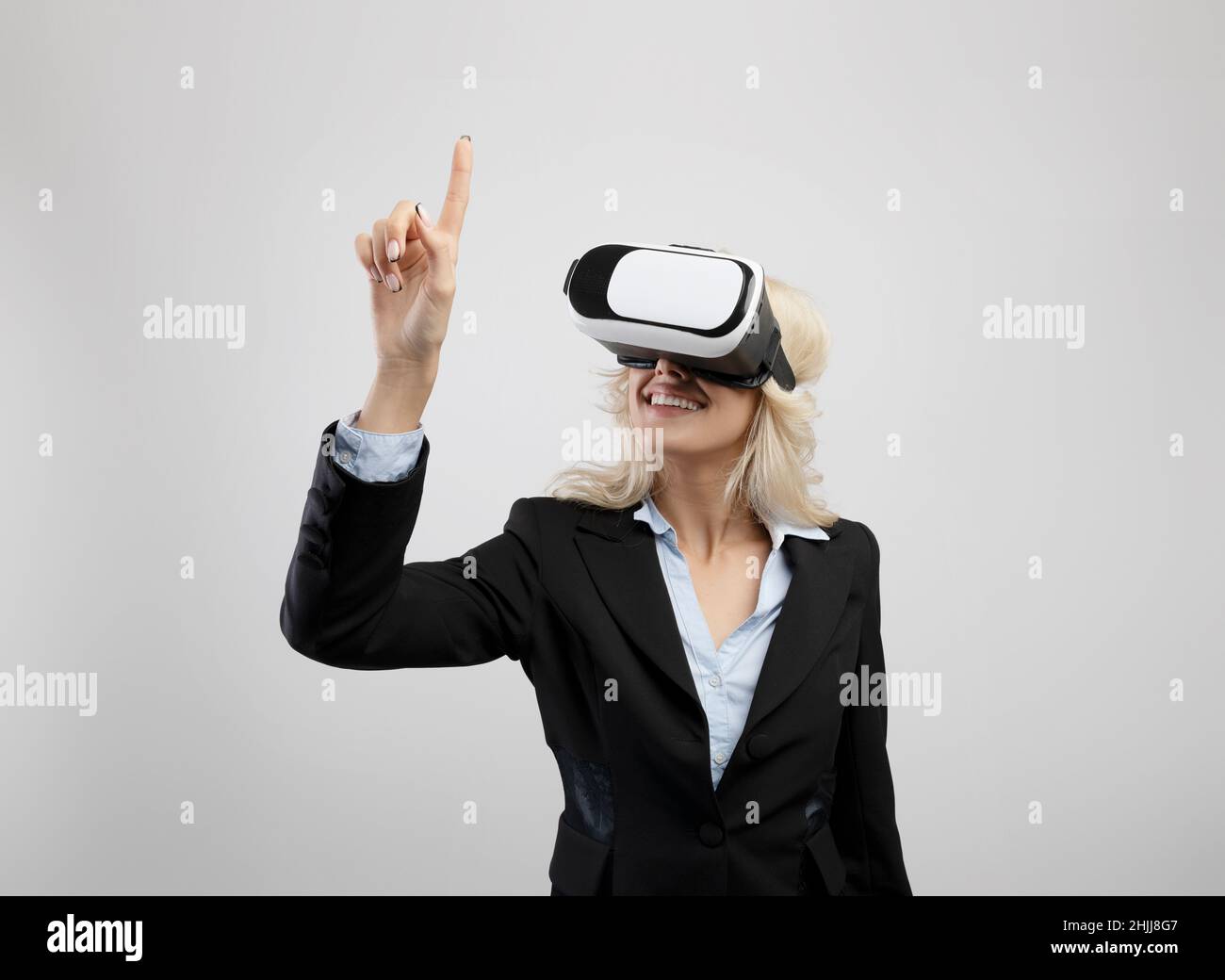 Businesswoman in VR headset touching virtual screen, exploring ...