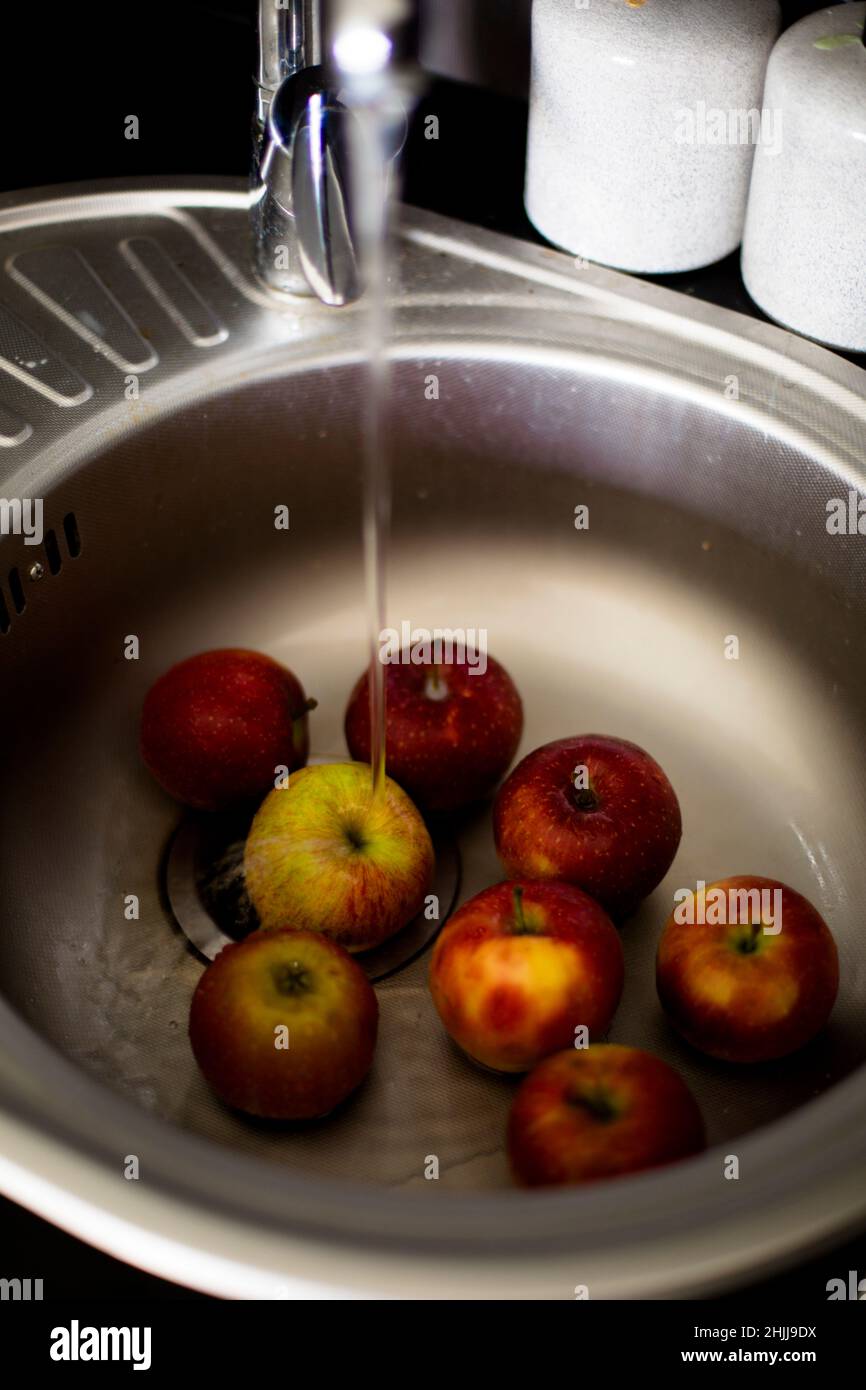 apples are washed in a sink under a tap under running water Stock Photo ...
