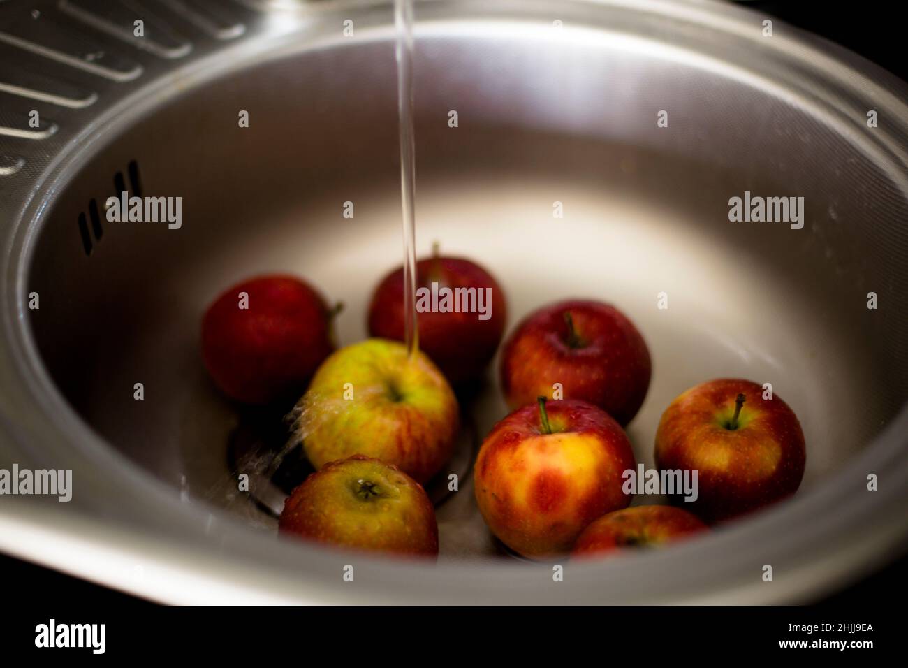 apples are washed in a sink under a tap under running water Stock Photo ...
