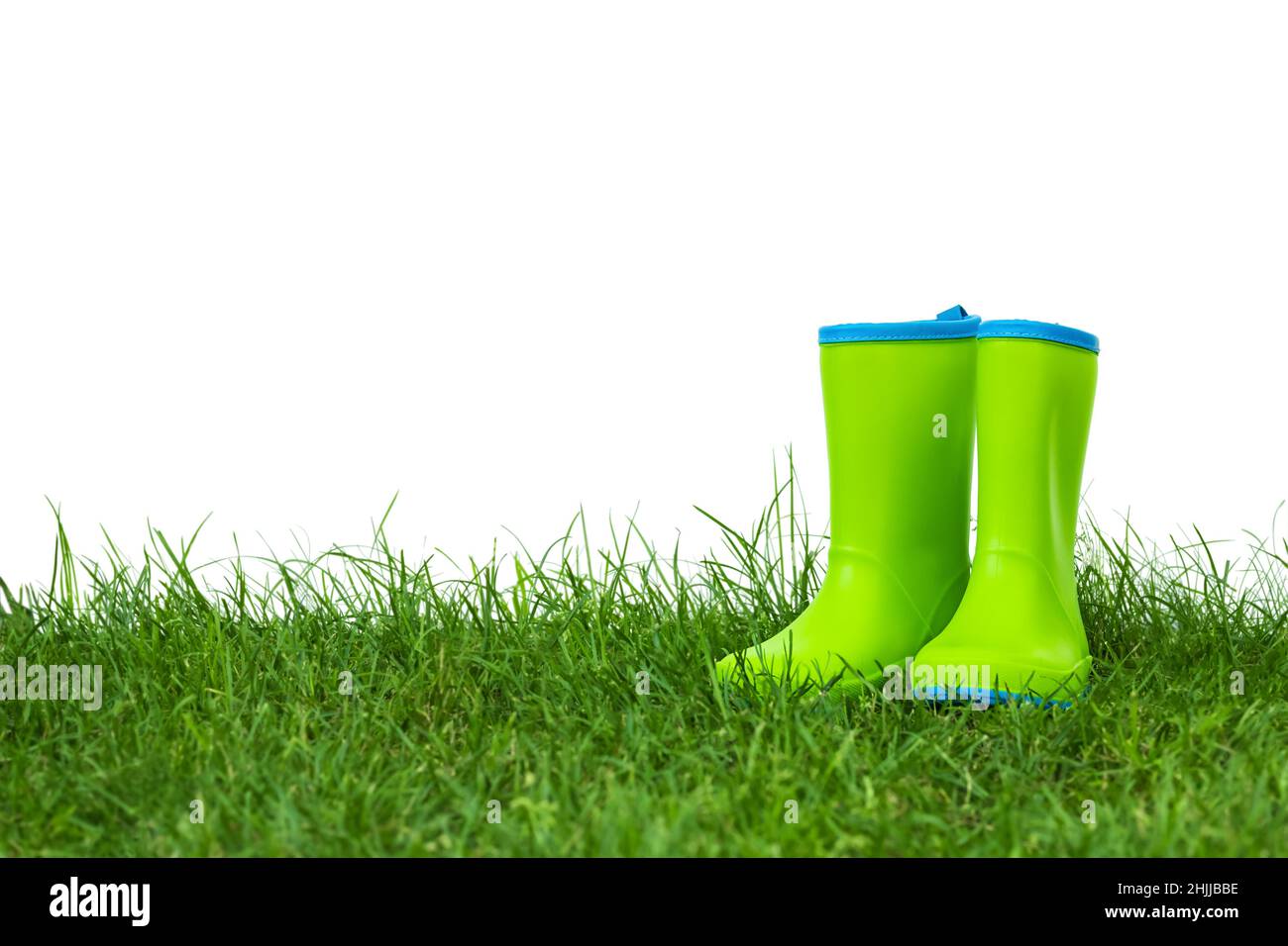 Green rubber boots on green grass close-up. White background, isolated ...