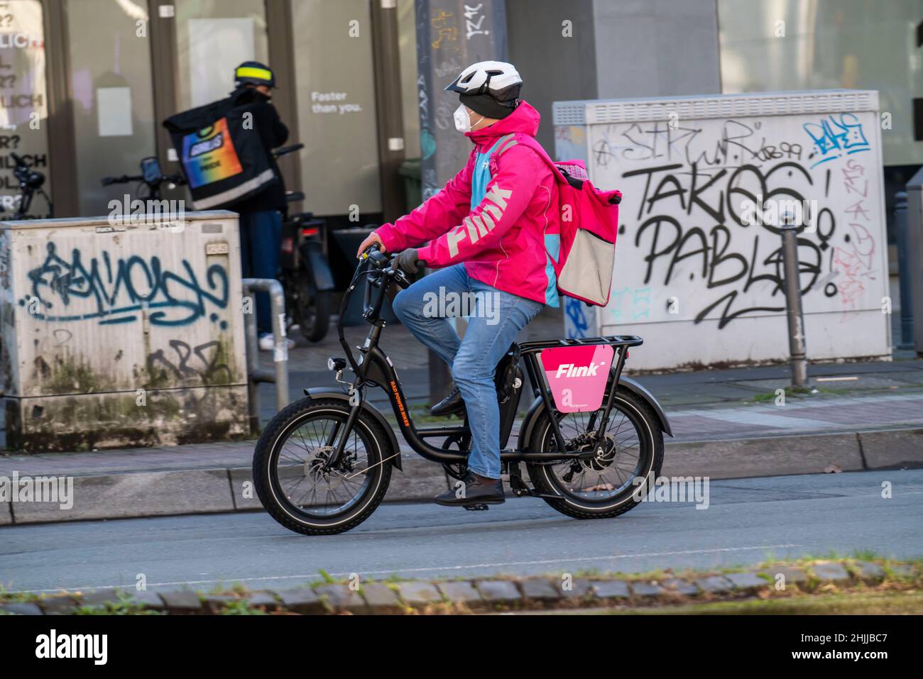 Bicycle courier of the fast delivery service Flink, delivers groceries ...