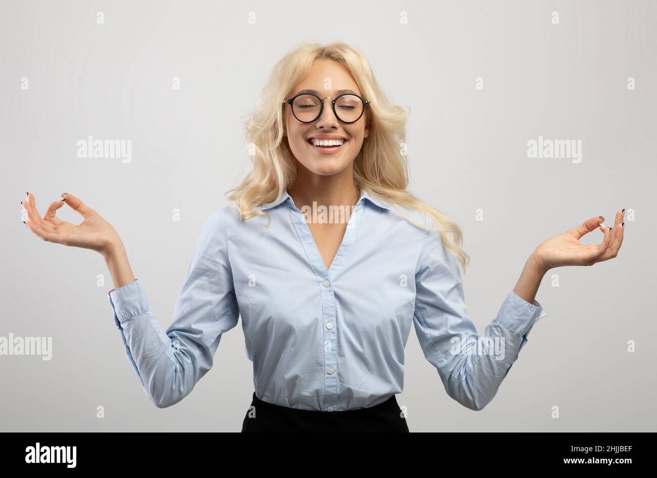 Calm and happy business lady in formal wear meditating on light grey ...