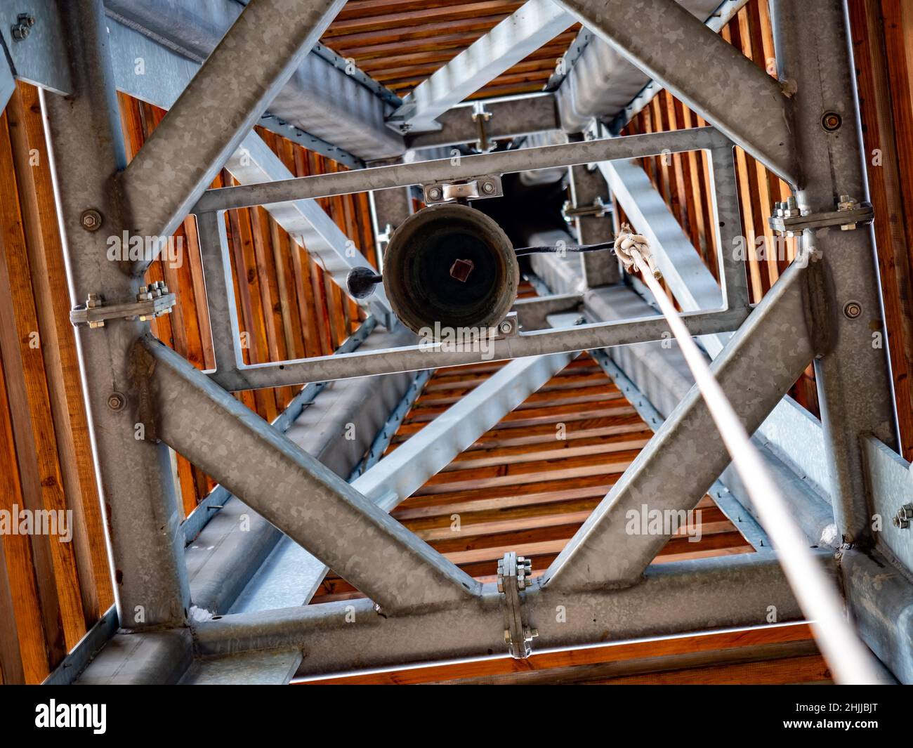 Bottom view to bell inside of bell tower. Riveted wooden steel ...