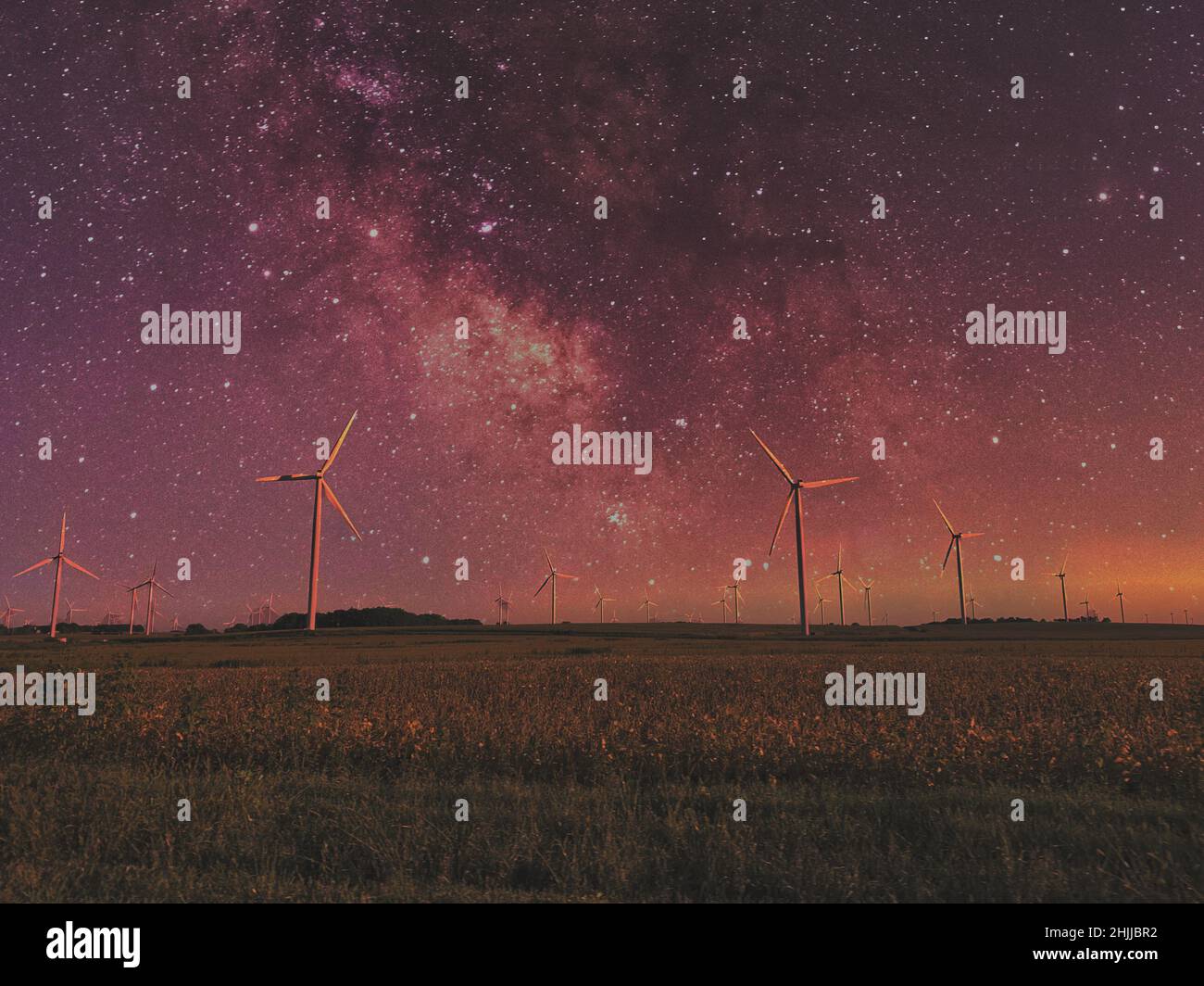Beautiful view of a wind turbine field under the purple, starry sky ...