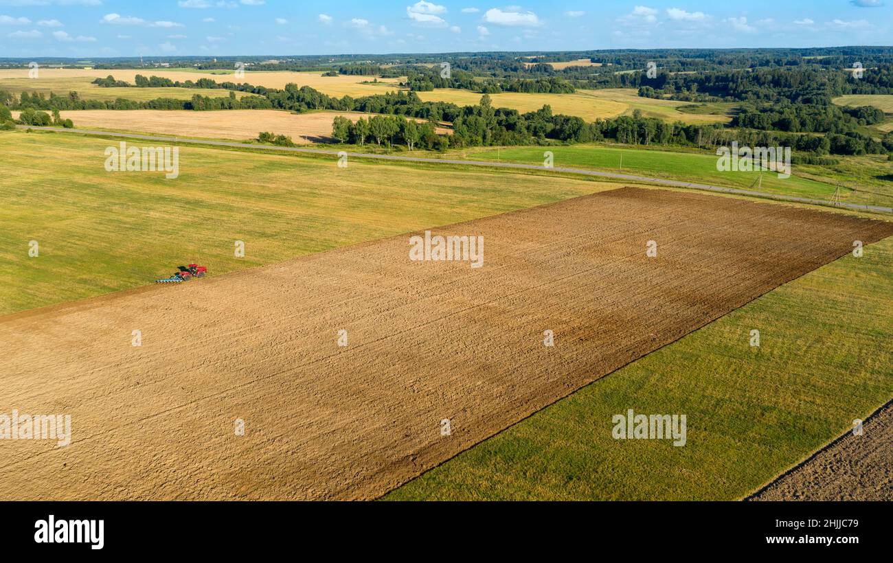 Scenic view of working tractor in the field agricultural field on a ...