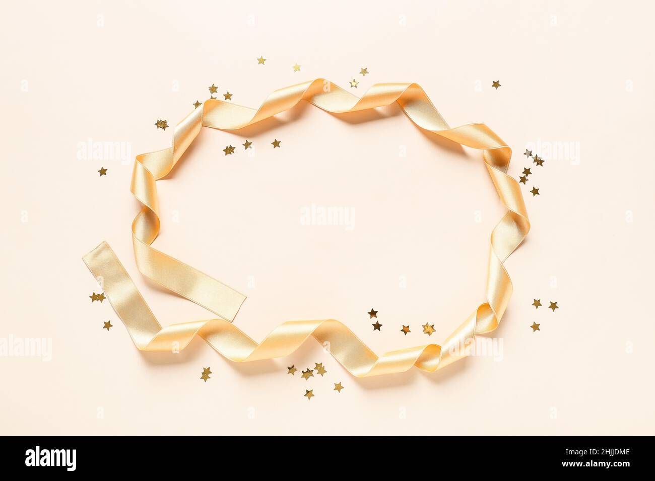 Frame made of golden ribbon and confetti on light background Stock ...