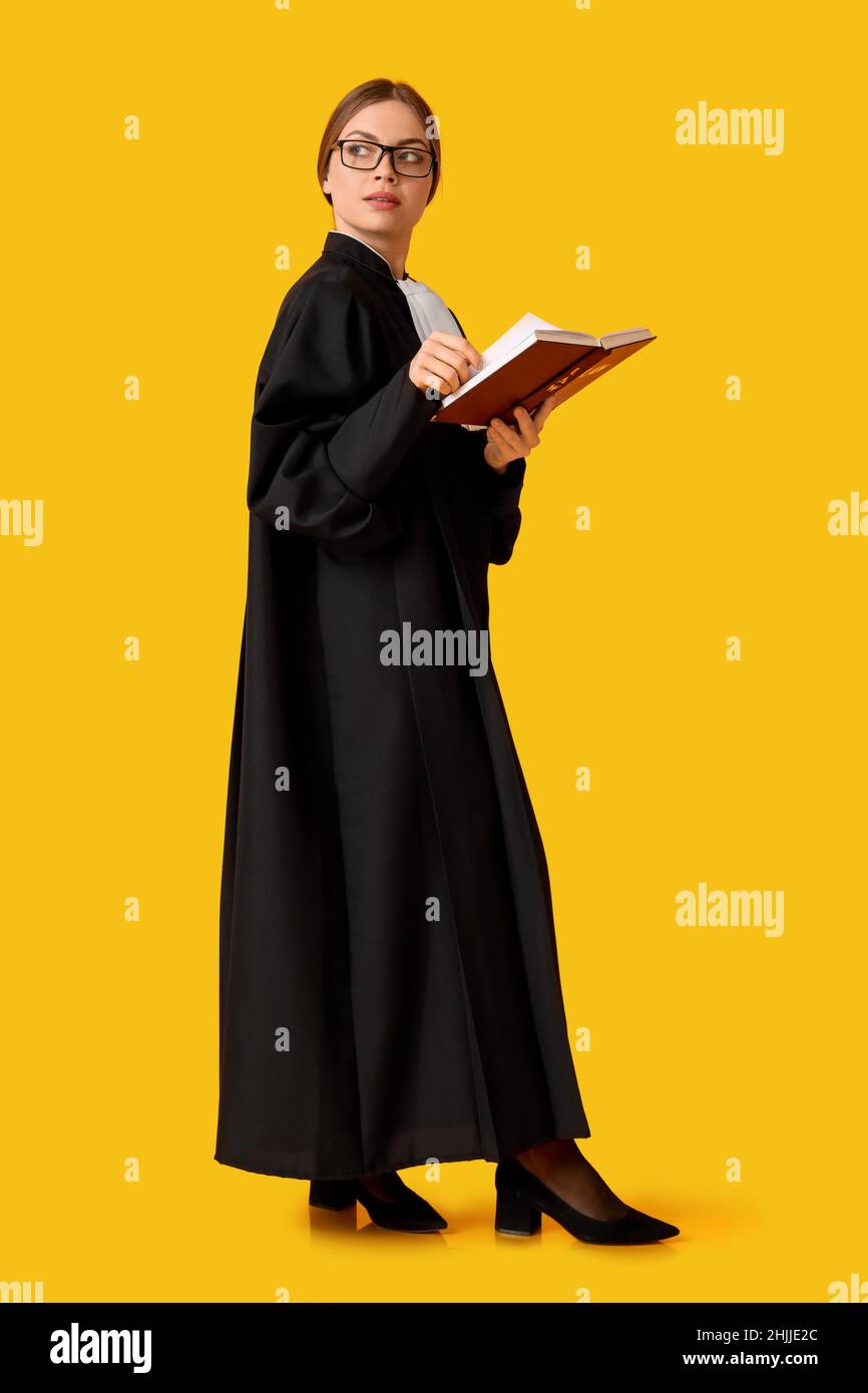 Young female judge with book on color background Stock Photo - Alamy