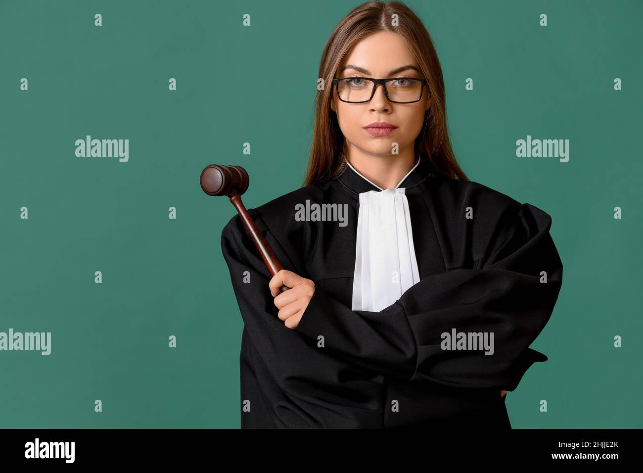 Young female judge with gavel on color background Stock Photo - Alamy
