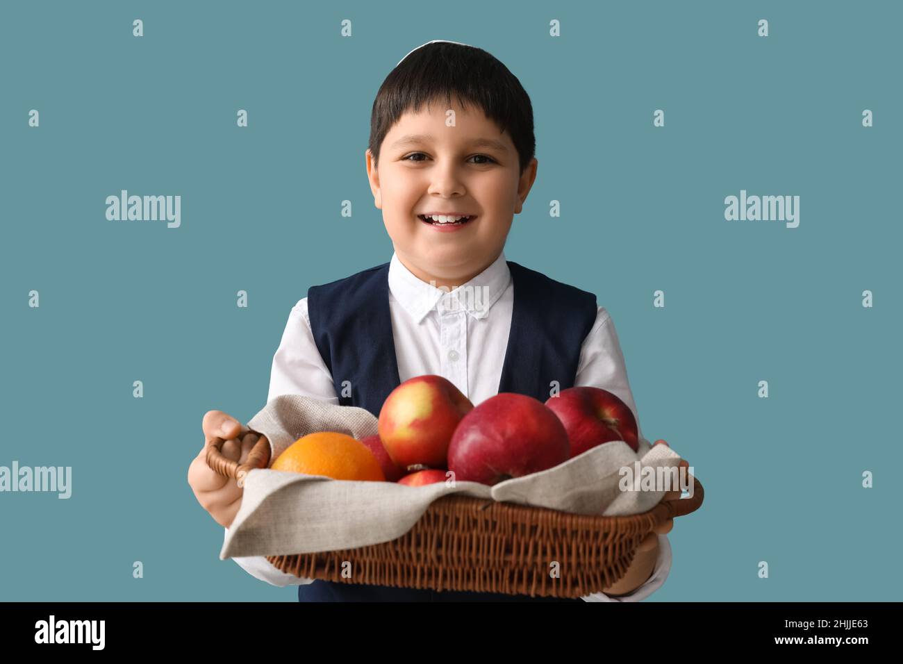 Little Jewish boy with fruits in basket on grey background Stock Photo ...