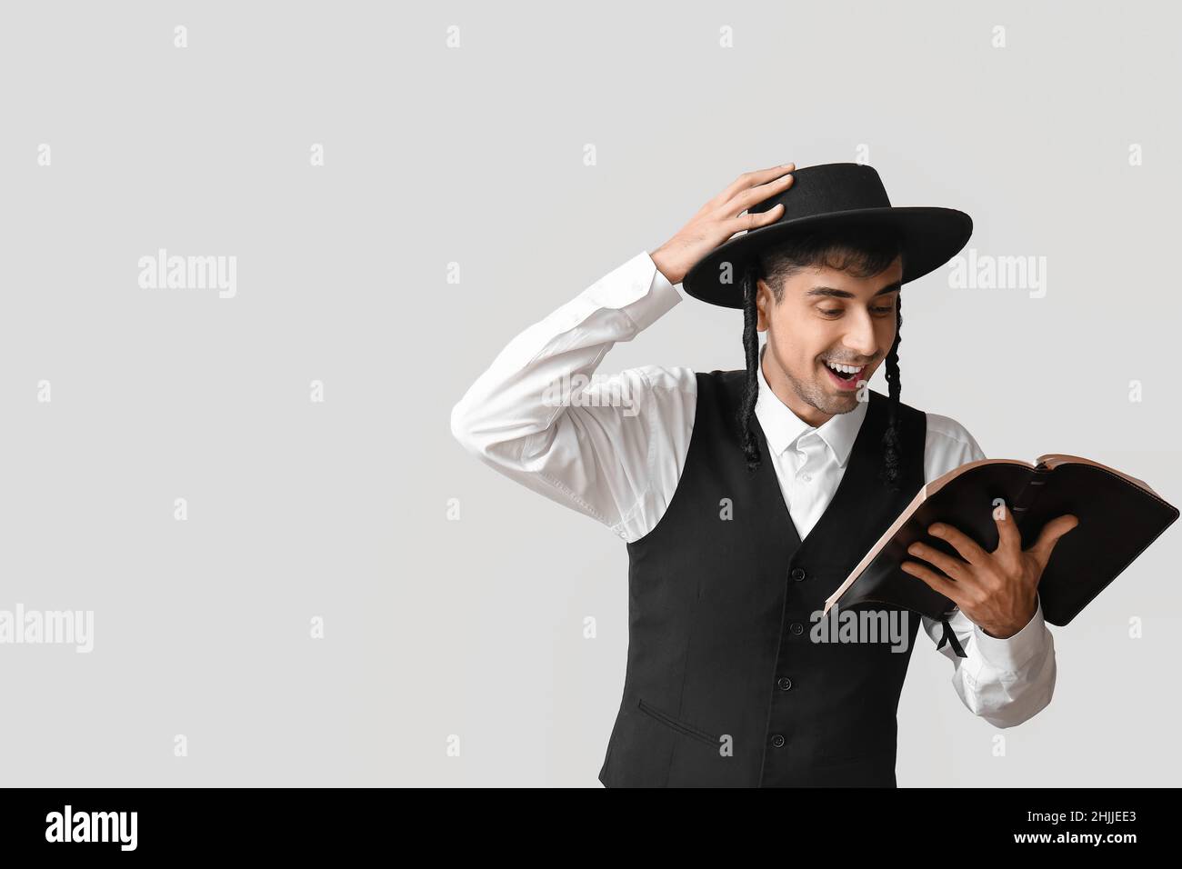 Happy Hasidic Jewish man with Torah on light background Stock Photo - Alamy