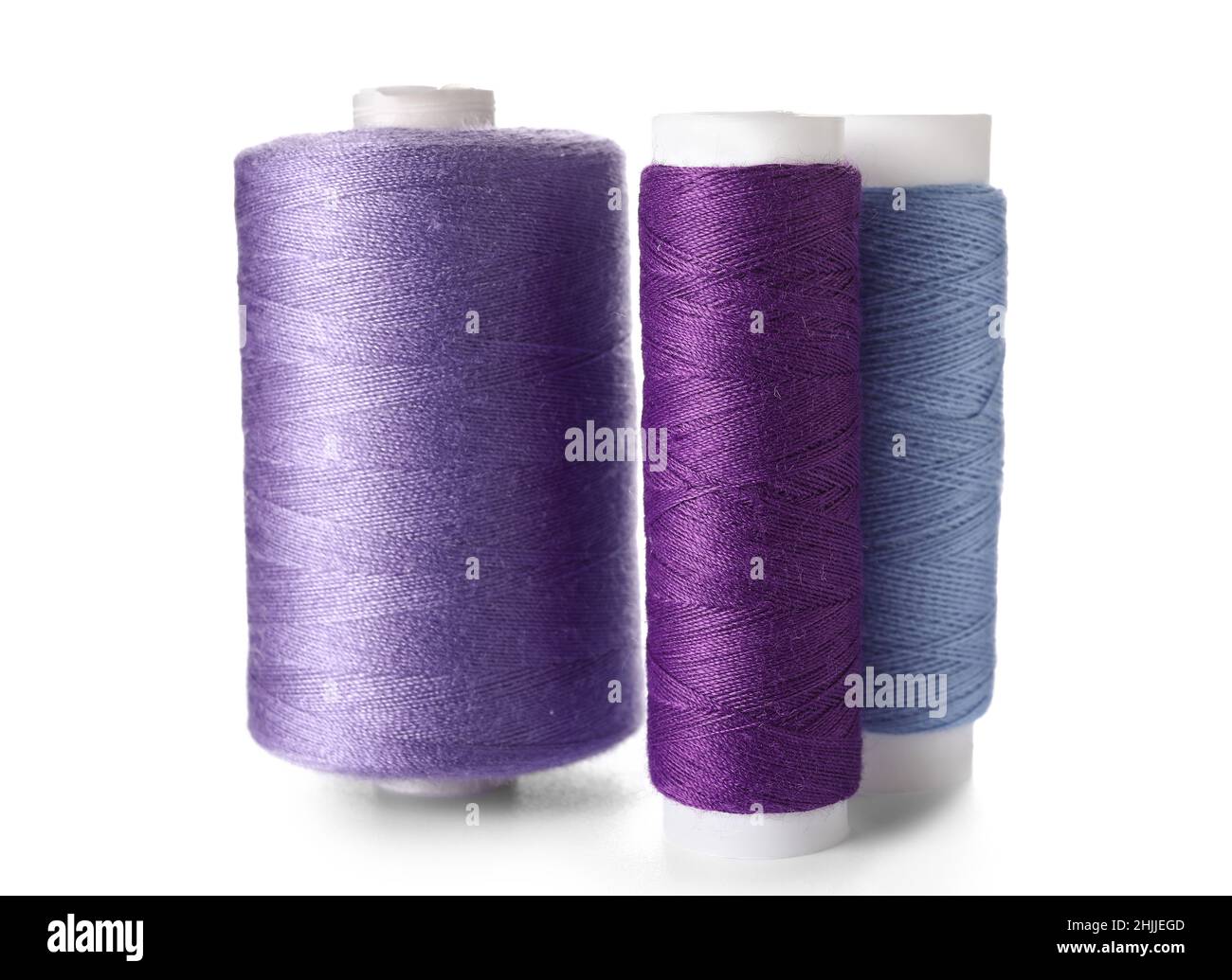 Purple sewing thread spools on white background Stock Photo - Alamy
