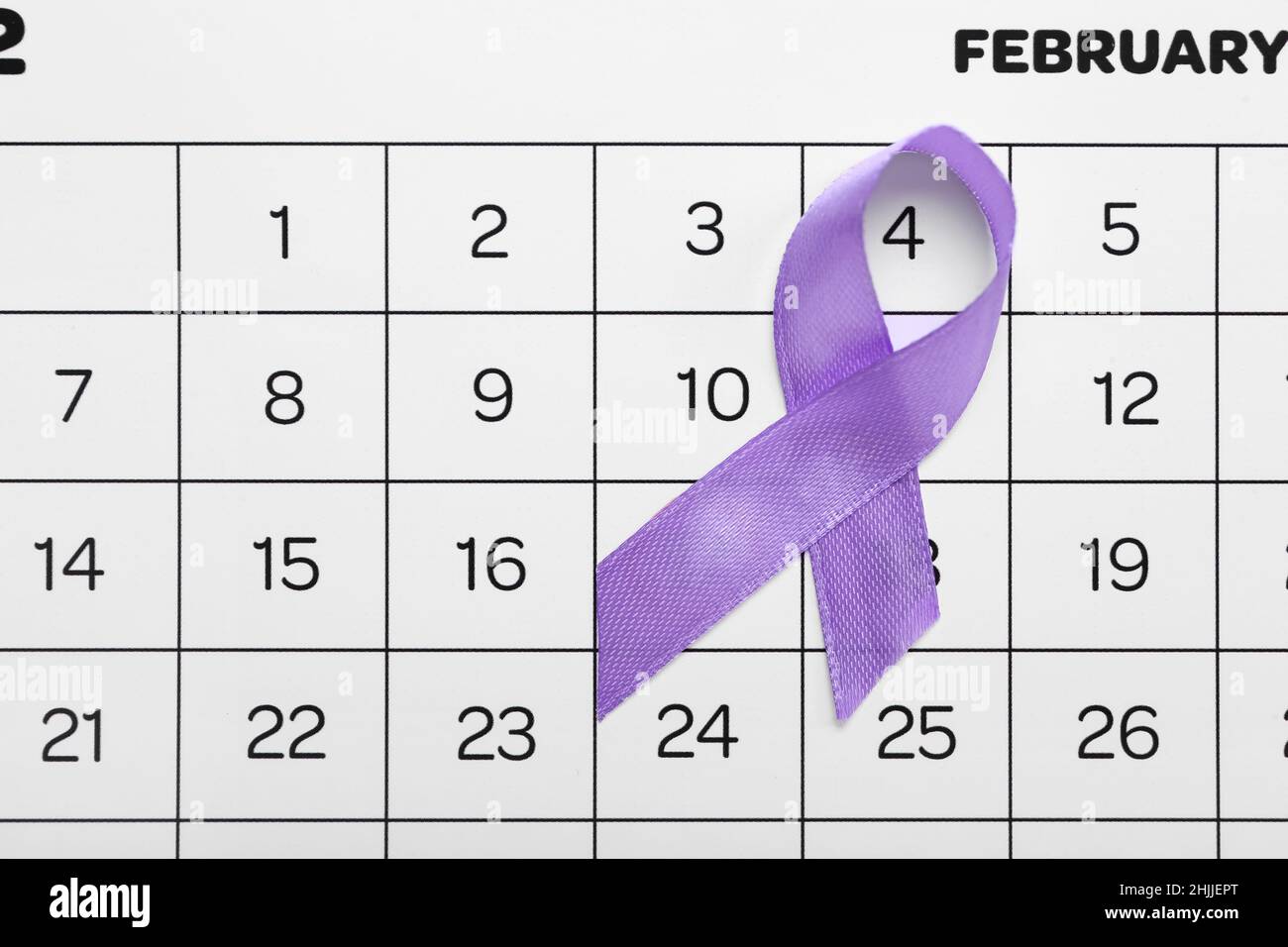 Awareness ribbon and paper calendar with marked date of World Cancer ...