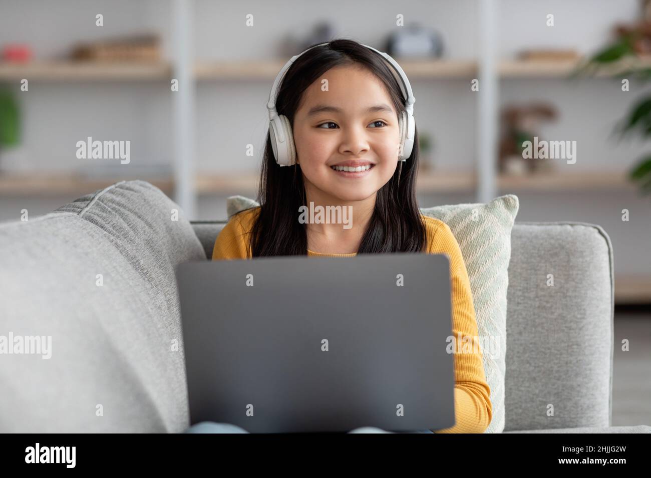 Positive asian child watching cartoon online, using computer Stock ...