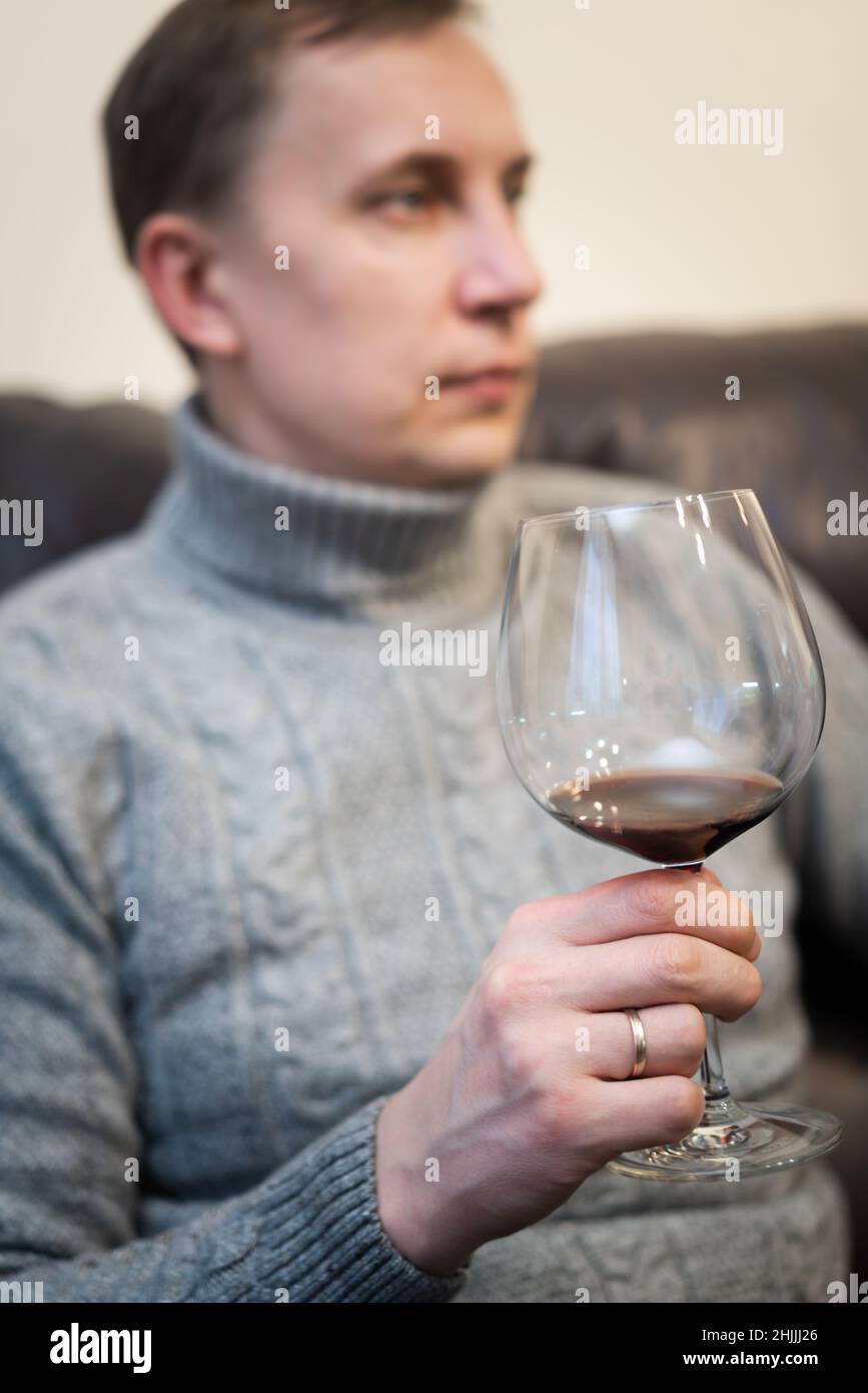 Relaxed serene rich lonely middle aged single man drinking red wine ...