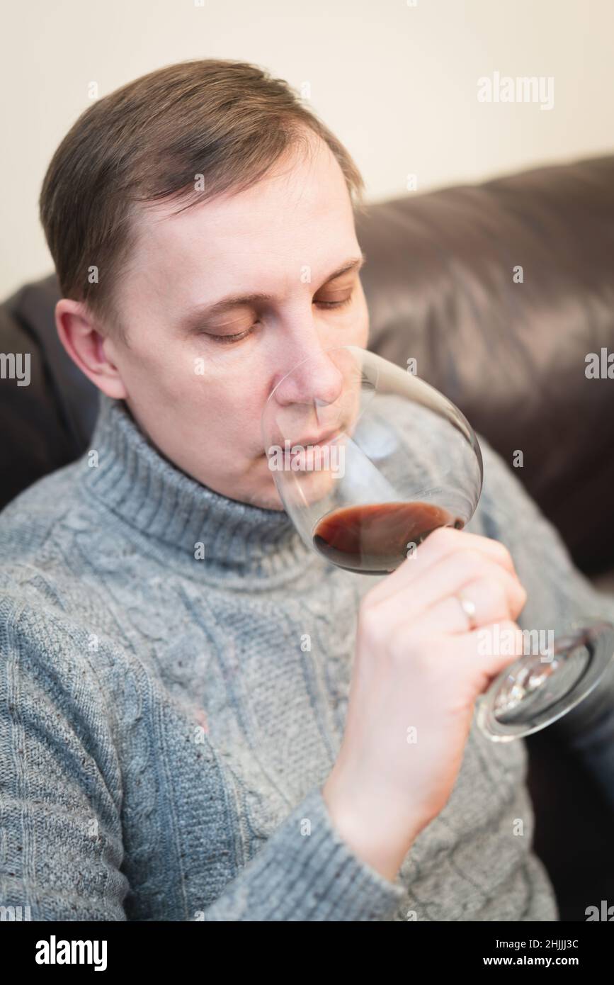 Relaxed serene rich lonely middle aged single man drinking red wine ...