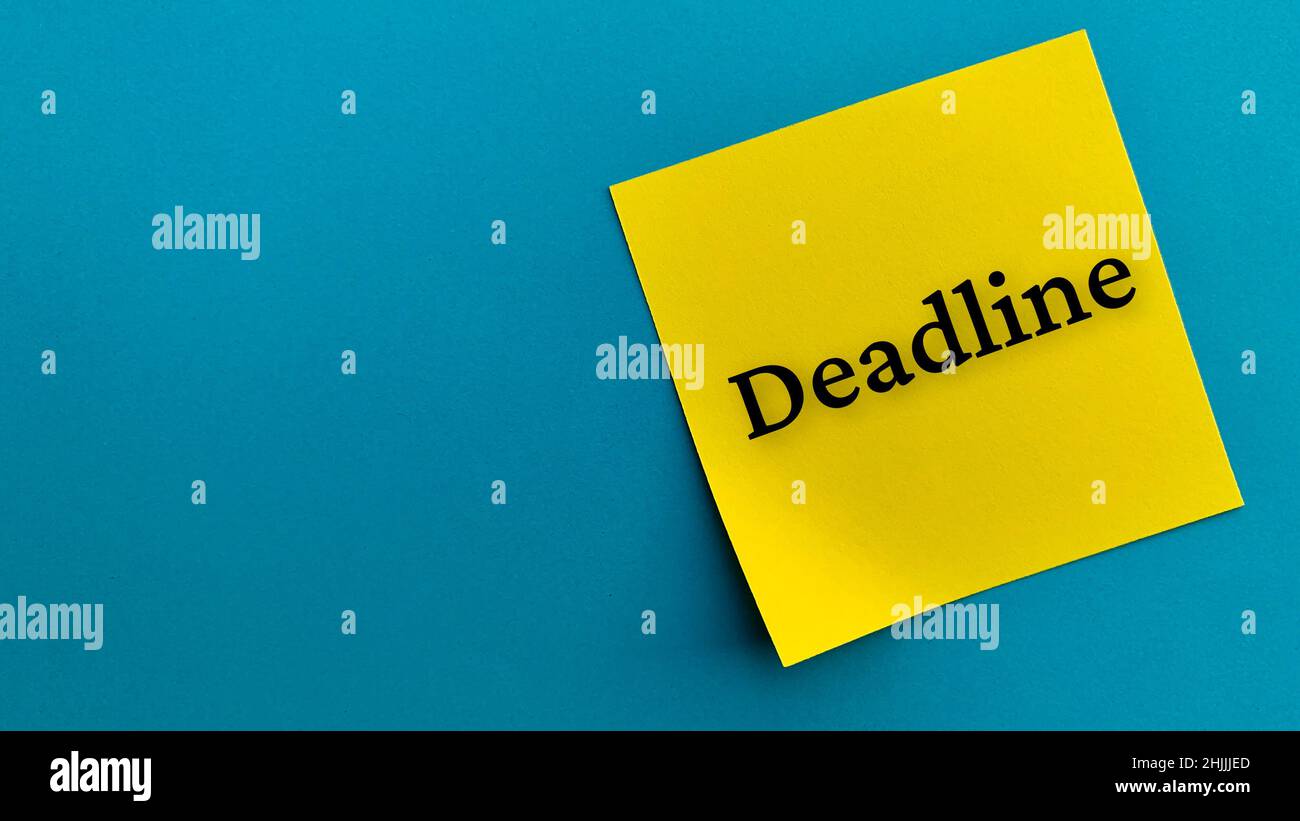 Top view of text - Deadline on sticky note with blue background ...