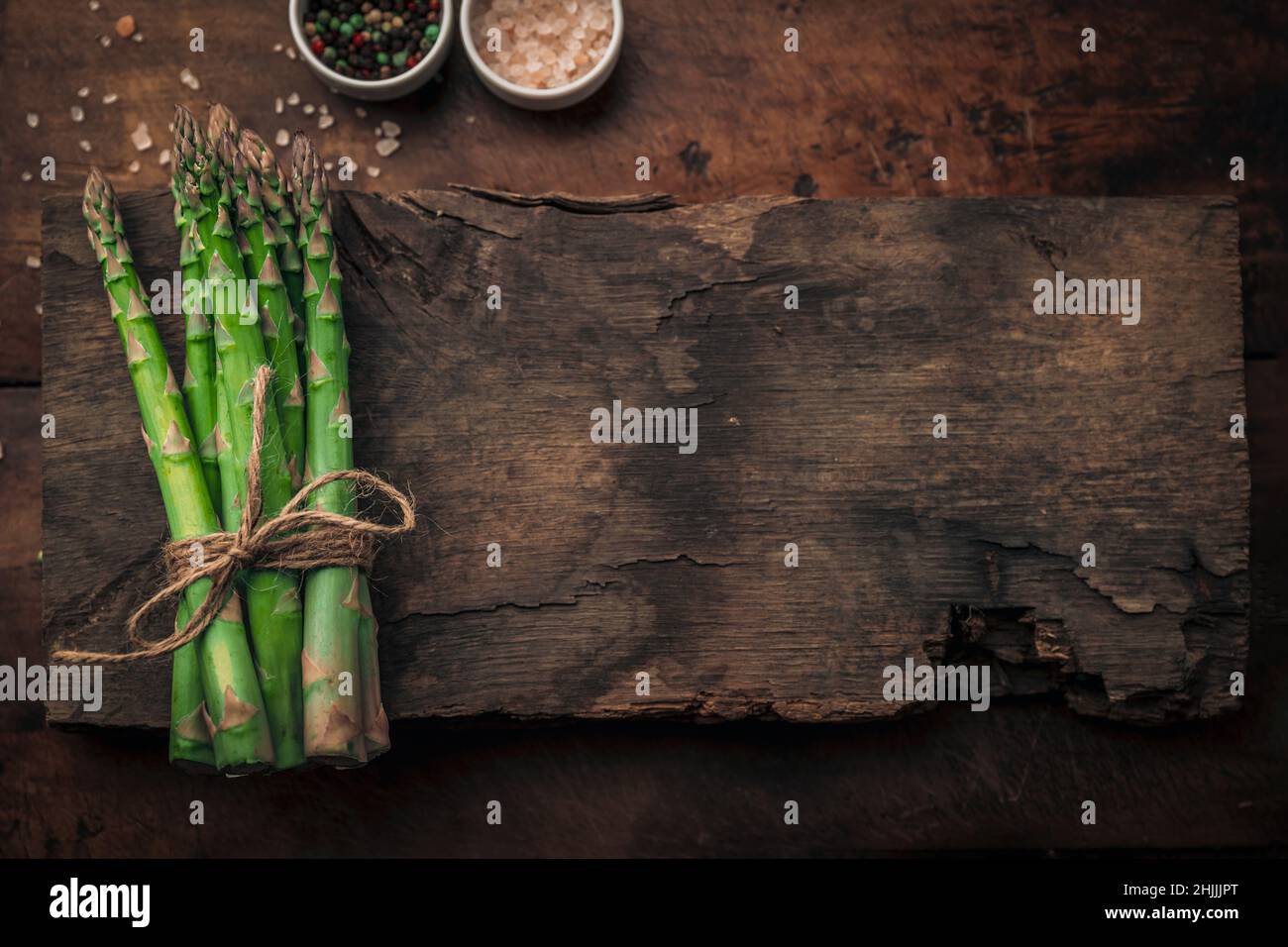 healthy living concept: fresh bunch of asparagus on an old piece of ...