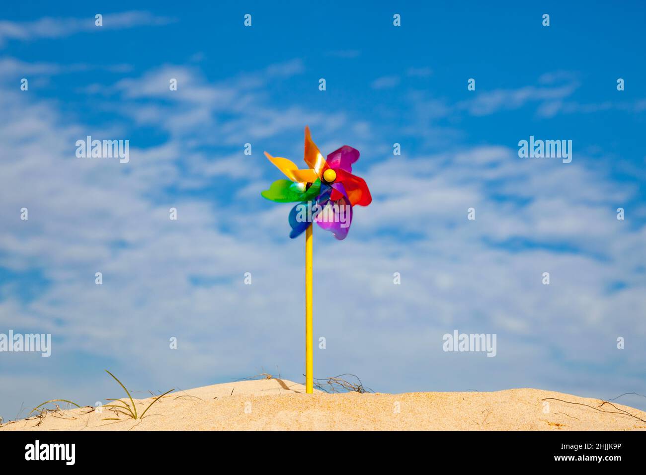 children's toy wind propeller in the sand as a symbol of renewable wind ...