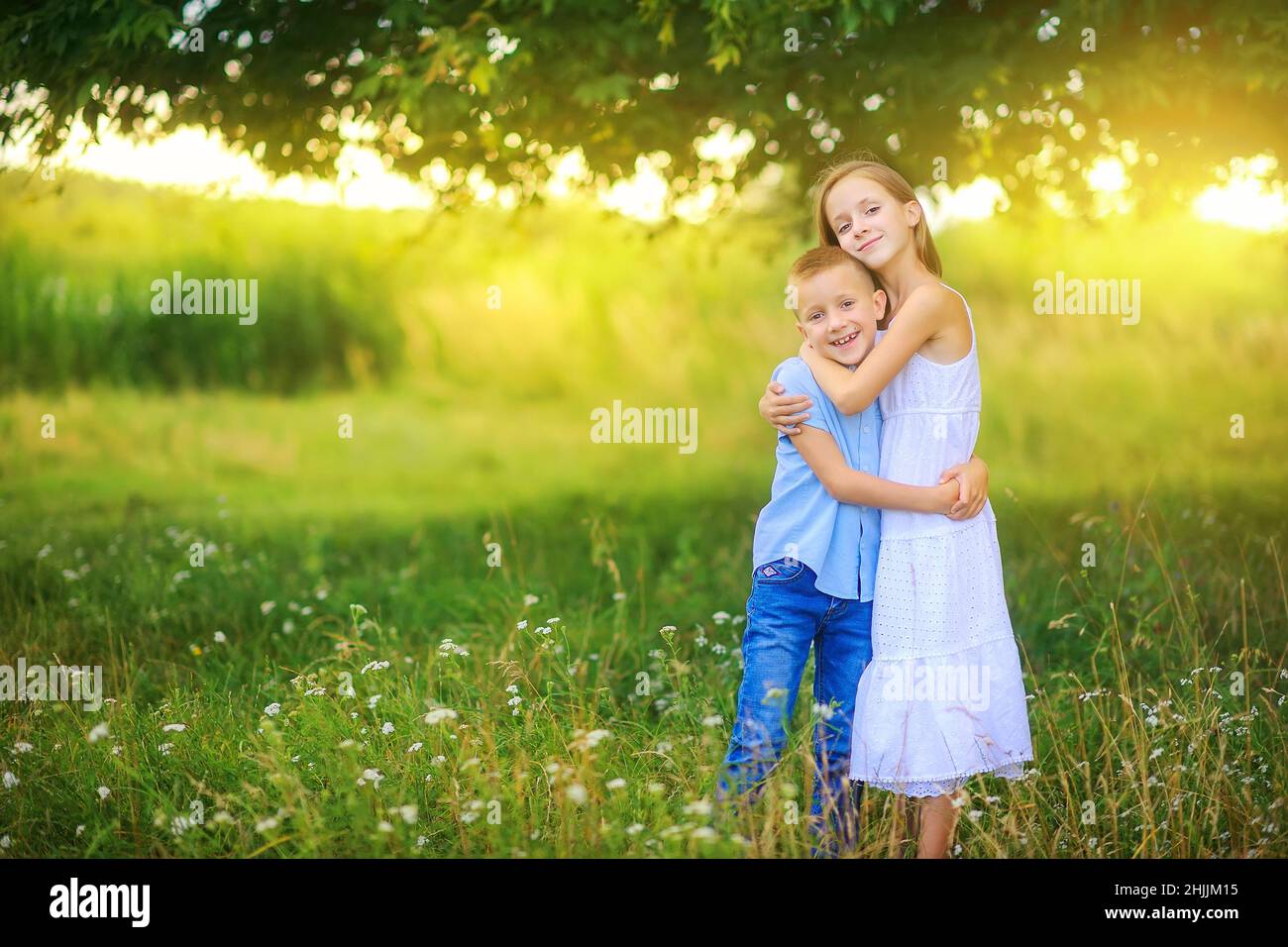 Cute children are walking in the evening park. Hug and smile. Children ...
