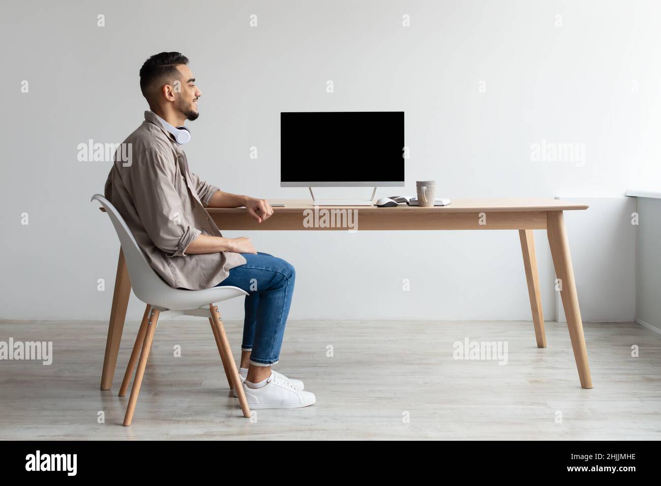 Arab man looking at blank empty computer monitor Stock Photo - Alamy