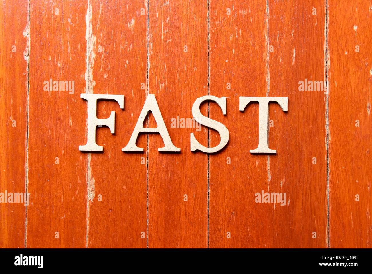 Alphabet letter in word fast on old red color wood plate background ...