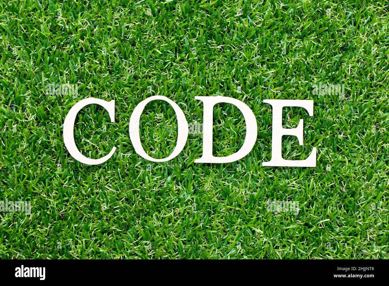 Wood letter in word code on green grass background Stock Photo - Alamy