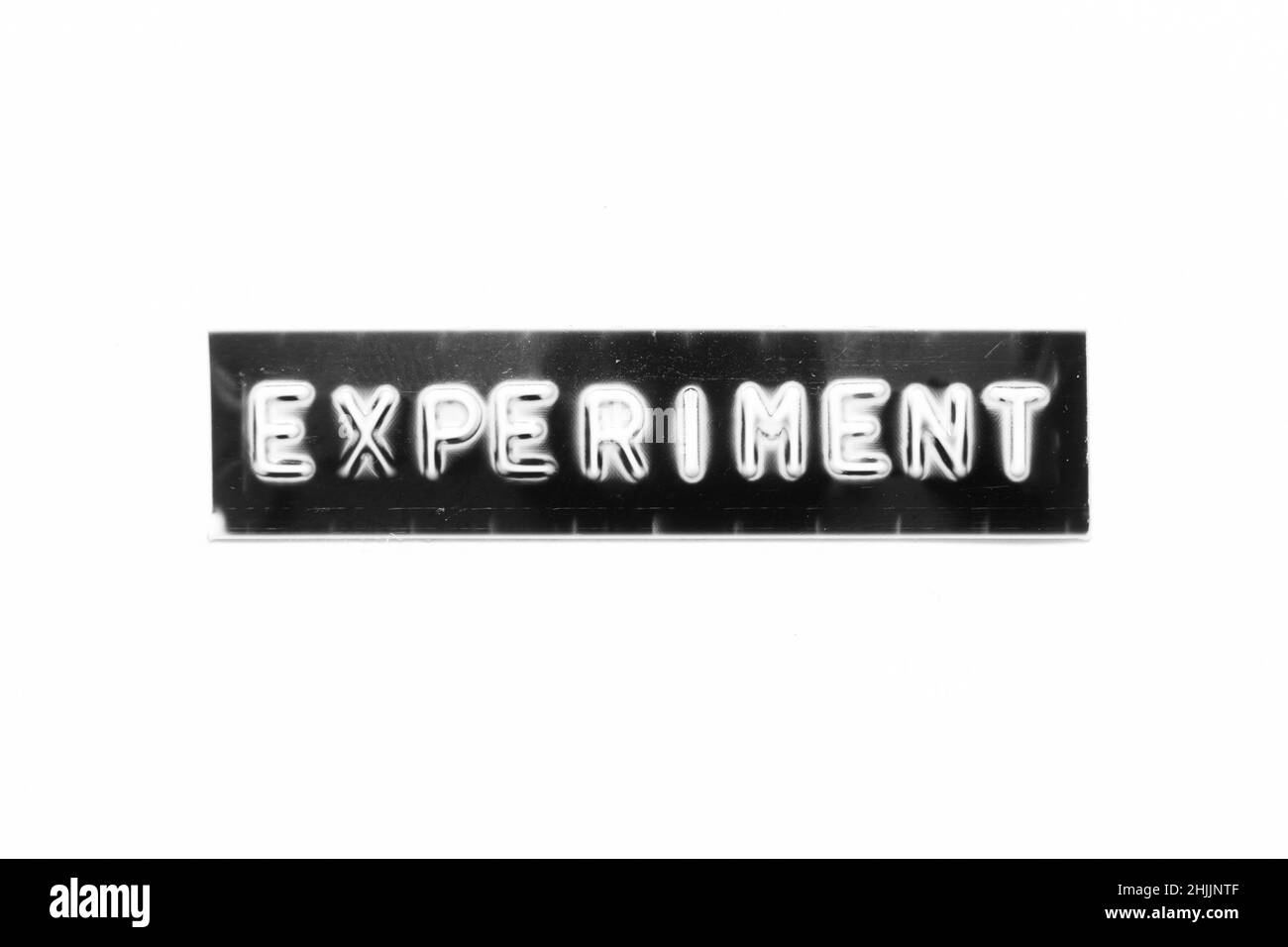Embossed letter with word experiment in black banner on white paper ...