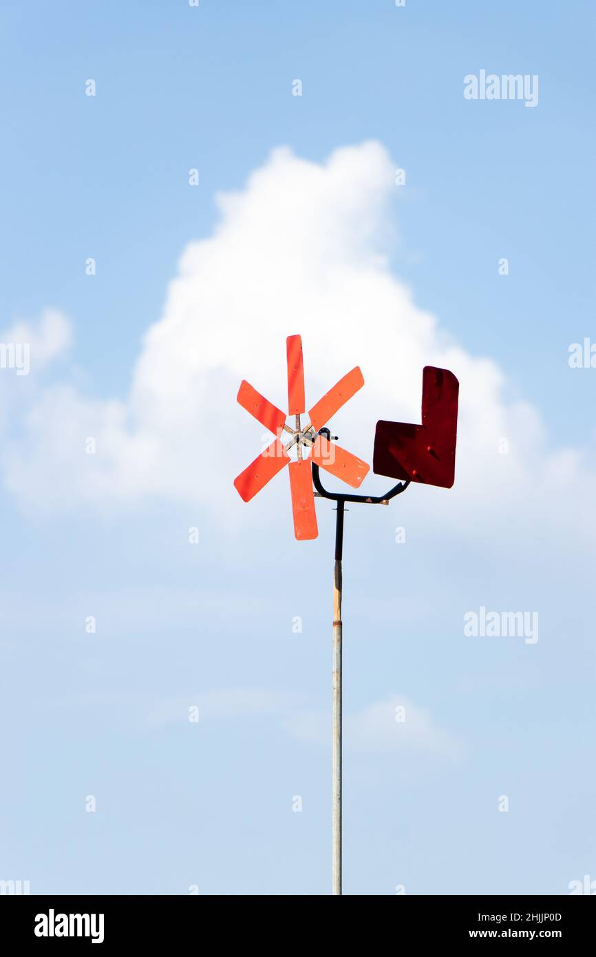 Red color windmill on blue sky background Stock Photo - Alamy