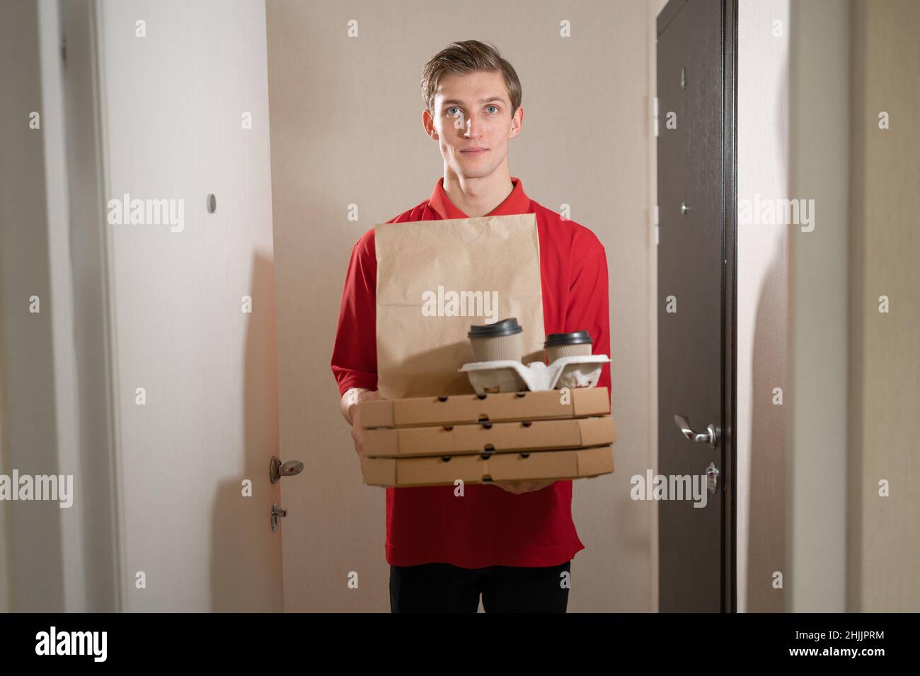 Pizza delivery concept. courier in uniform with boxes of pizza and ...