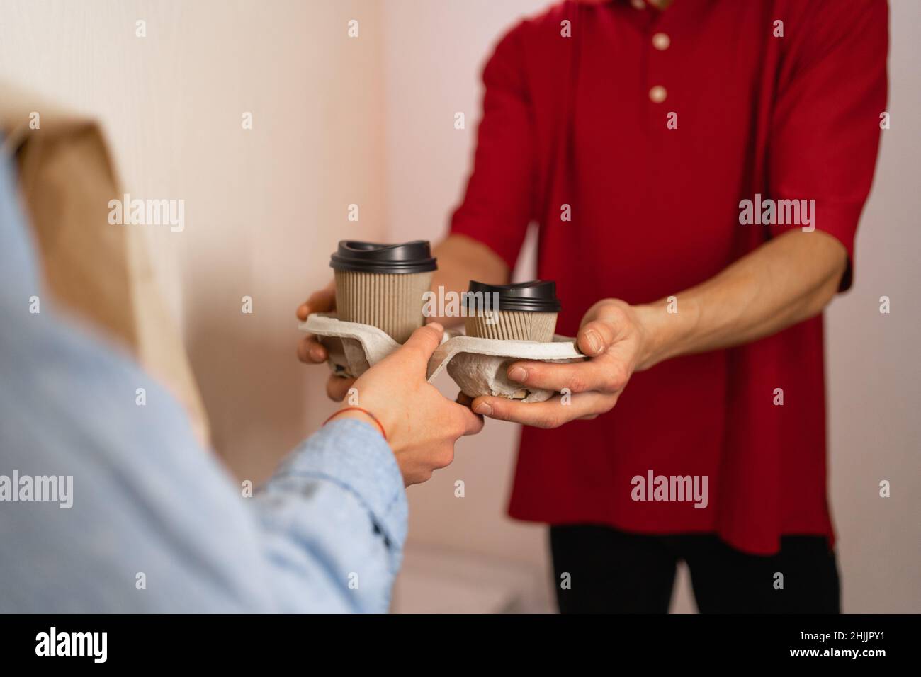 Home delivery food and coffee concept. Deliveryman passing coffee in ...