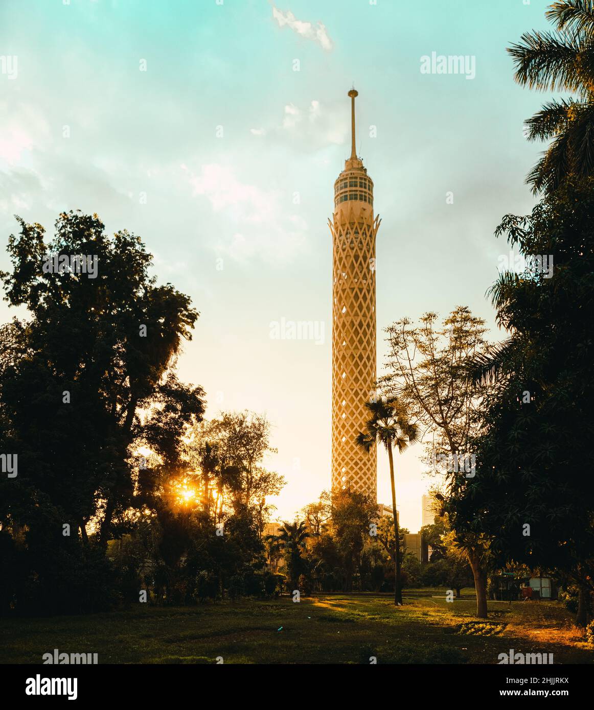 View of the iconic Cairo Tower an sunset, sunrays illuminating the park ...