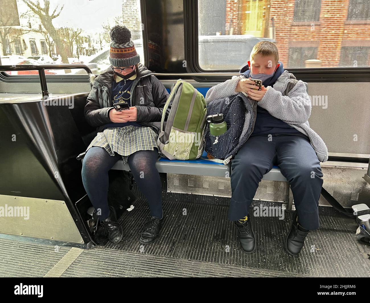 Students going home after school on a city bus glued to their phones in ...