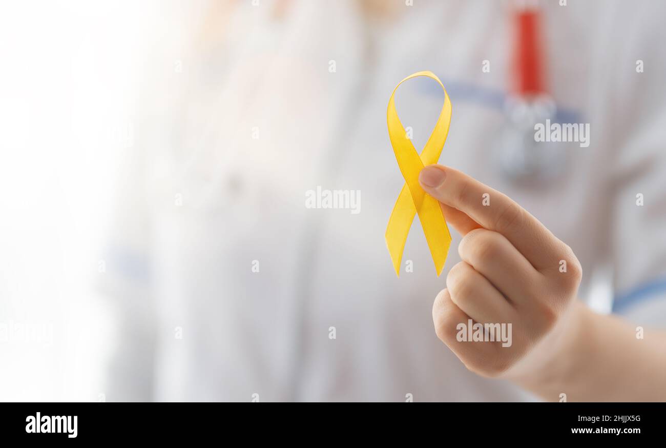 World Childhood cancer Day. Doctor with golden ribbon Stock Photo - Alamy