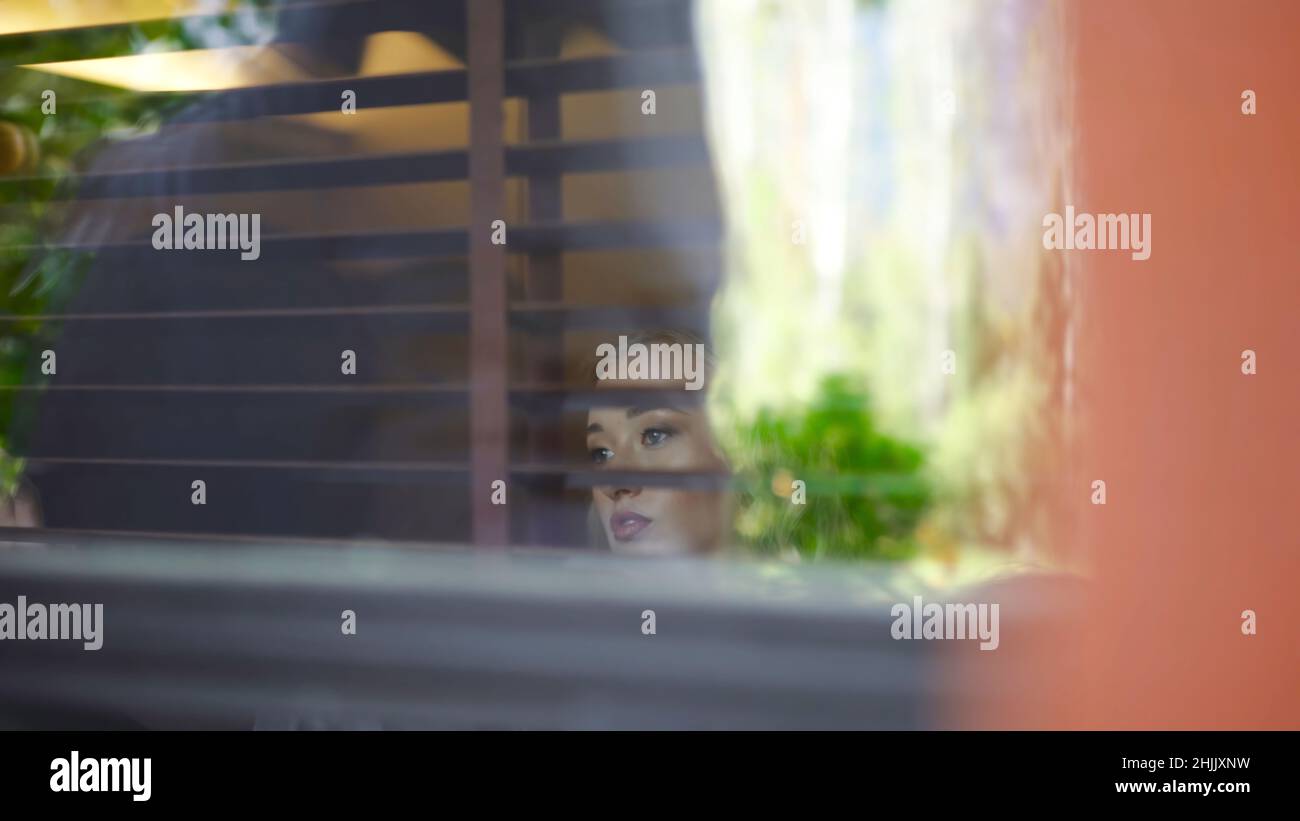 Young woman looks out the window of the house. Art. Beautiful blonde ...