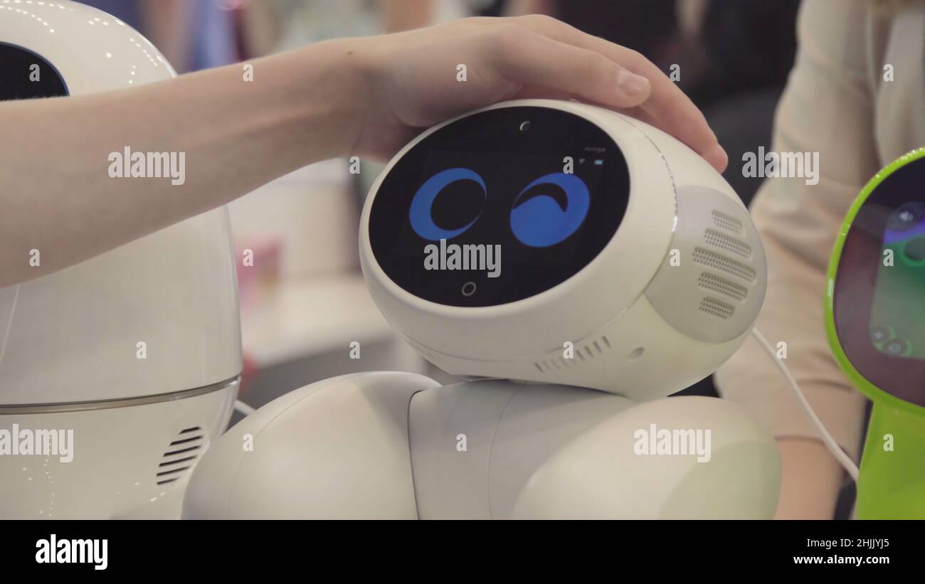 Hand of man touches the robot. Robot is happy with the touch of a human ...