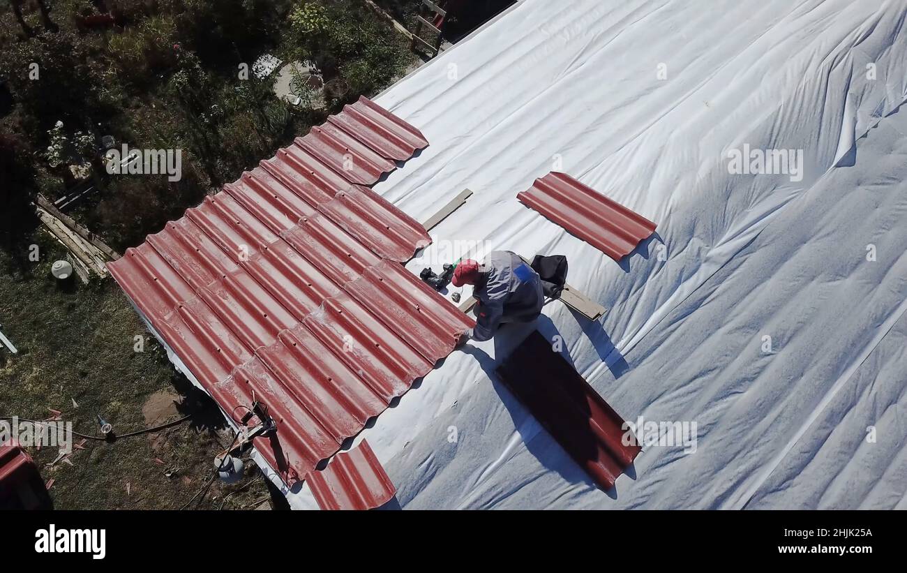 Man making roof of country house. Stock footage. Top view of builder ...