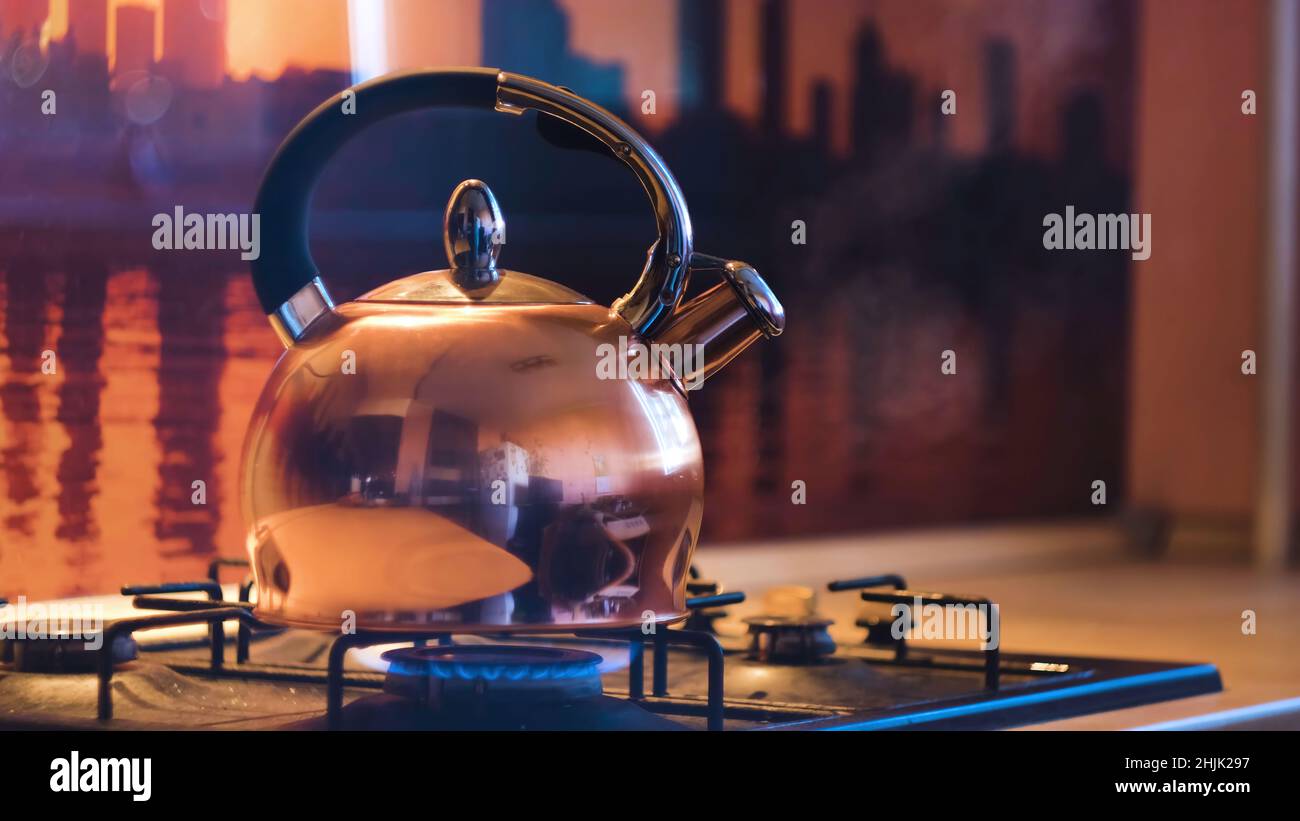 Close-up of silver teapot boiling on stove. Concept. Boiling kettle on stove in beautiful ...