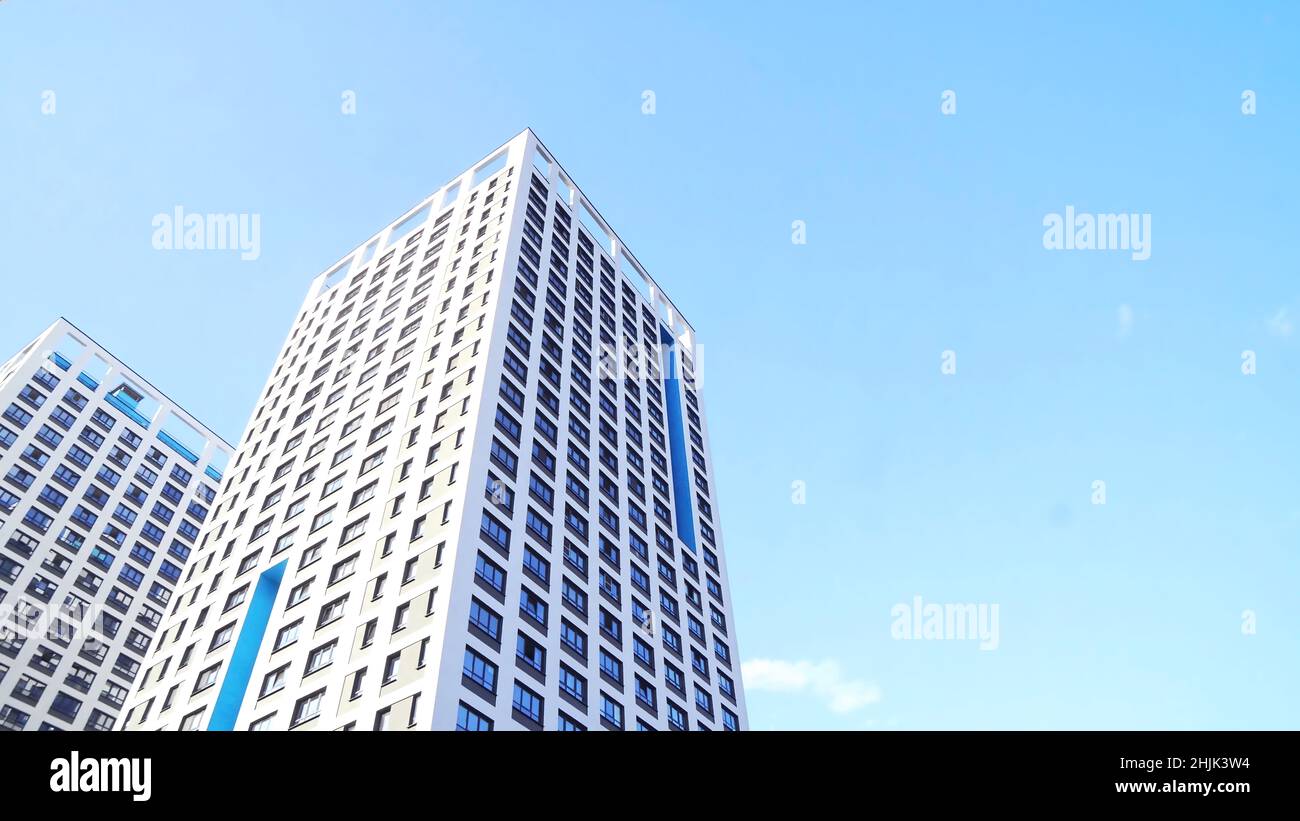 Bottom view of new residential high-rise buildings with blue sky. Urban ...