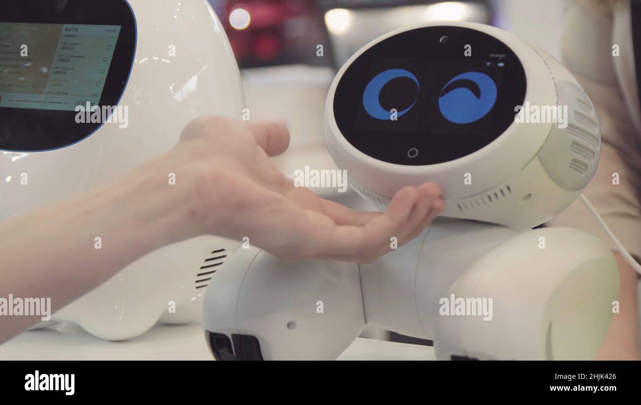 Hand of man touches the robot. Robot is happy with the touch of a human ...