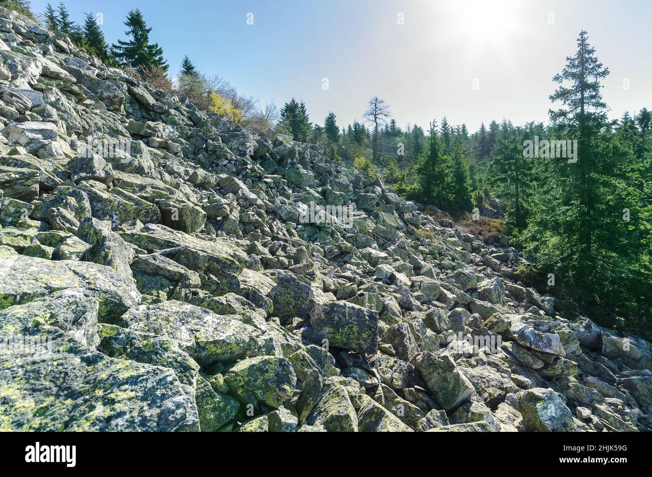 The rock slide in the mountains in sunny day, boulders covered with ...