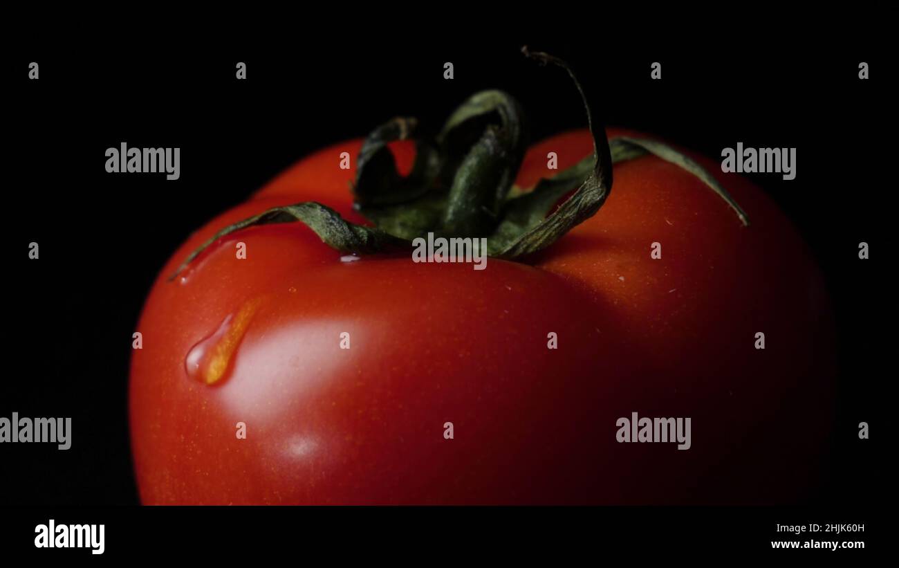 Drops of water dripping from above ripe tomatoes. Frame. Close up of a ...